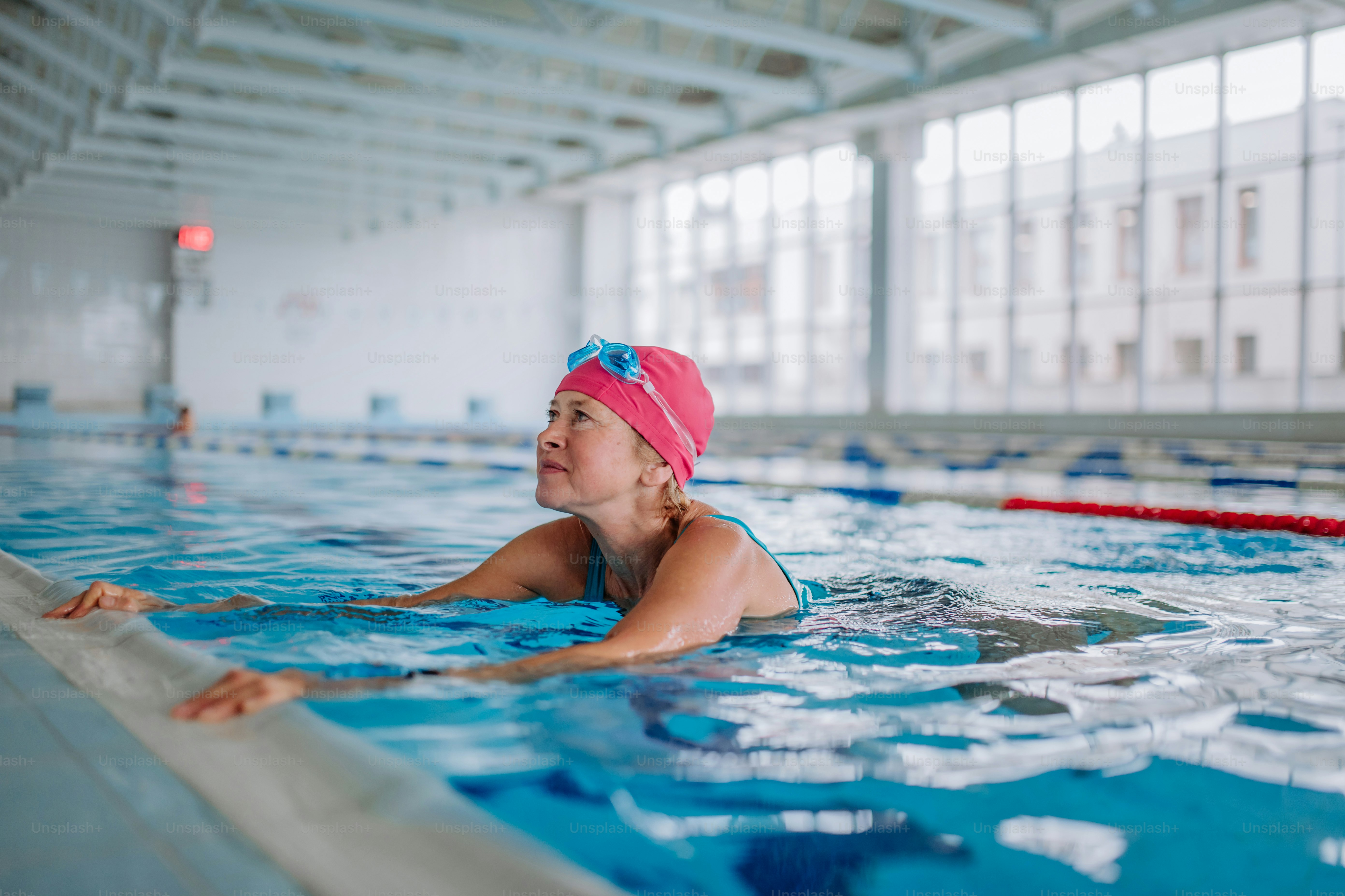 A happy senior woman in swimming pool, leaning on edge. photo – Swiming ...