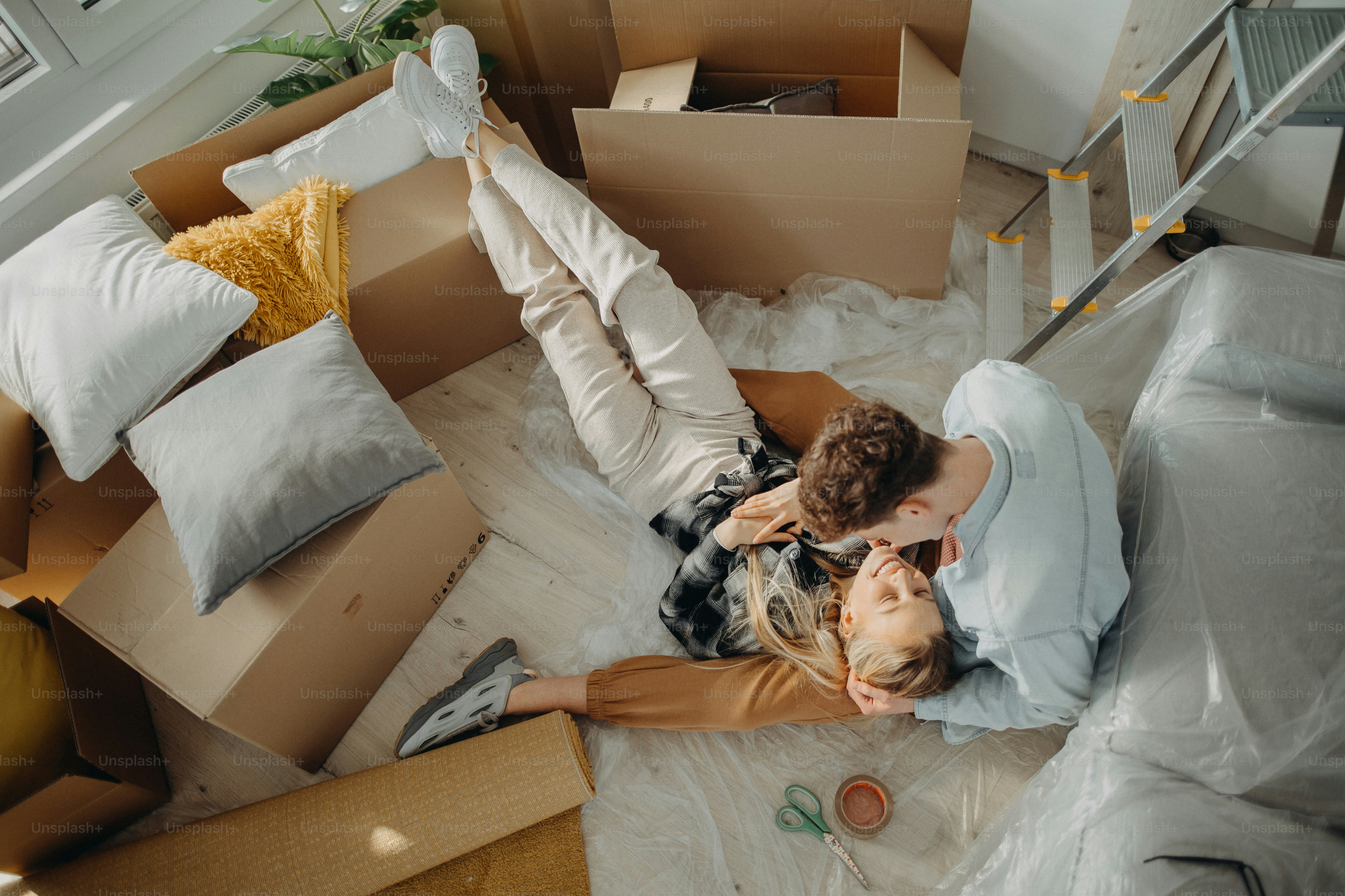 A cheerful young couple in their new apartment. Conception of moving ...