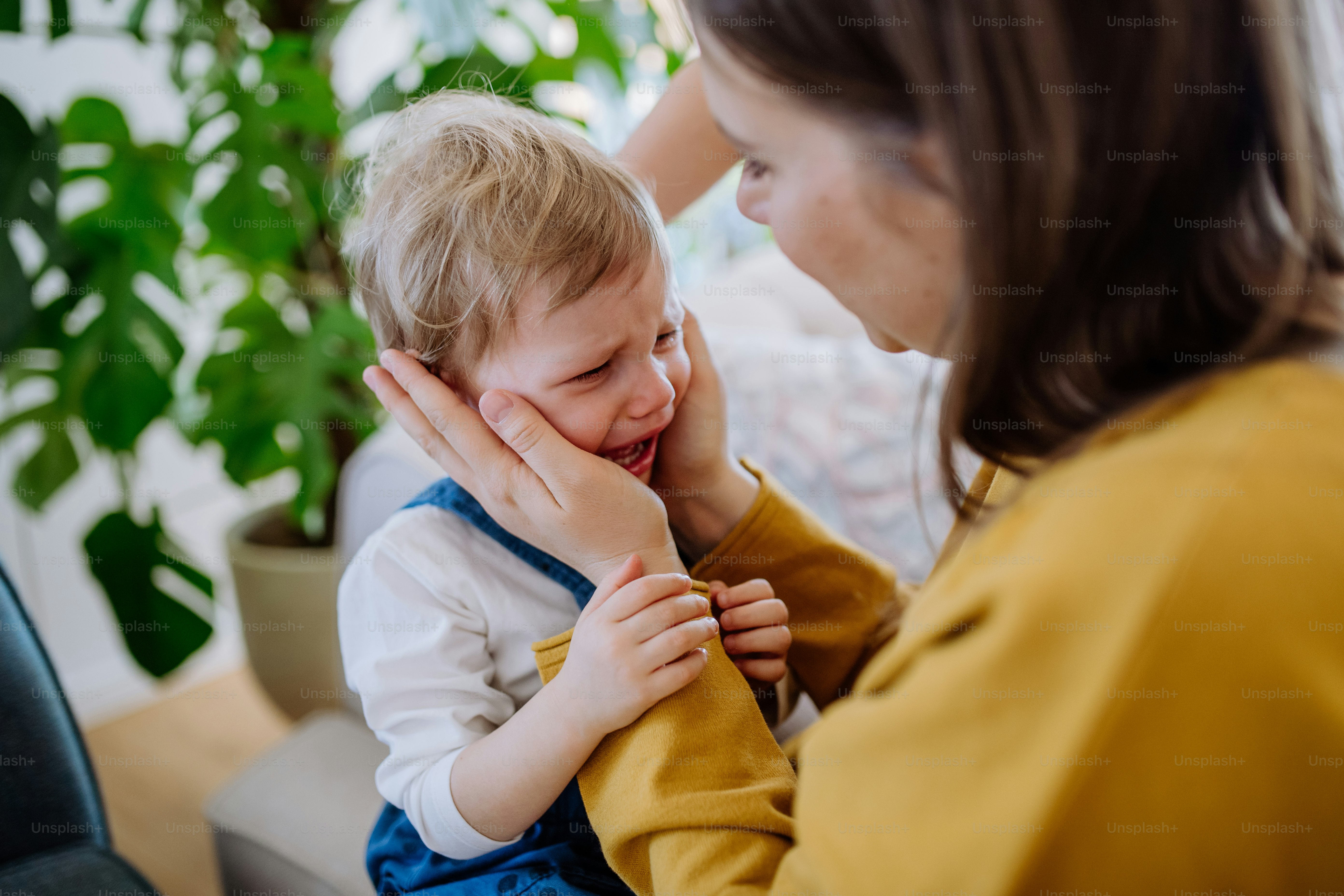 A mother consoling her little upset daughter at home. photo – Baby cry ...