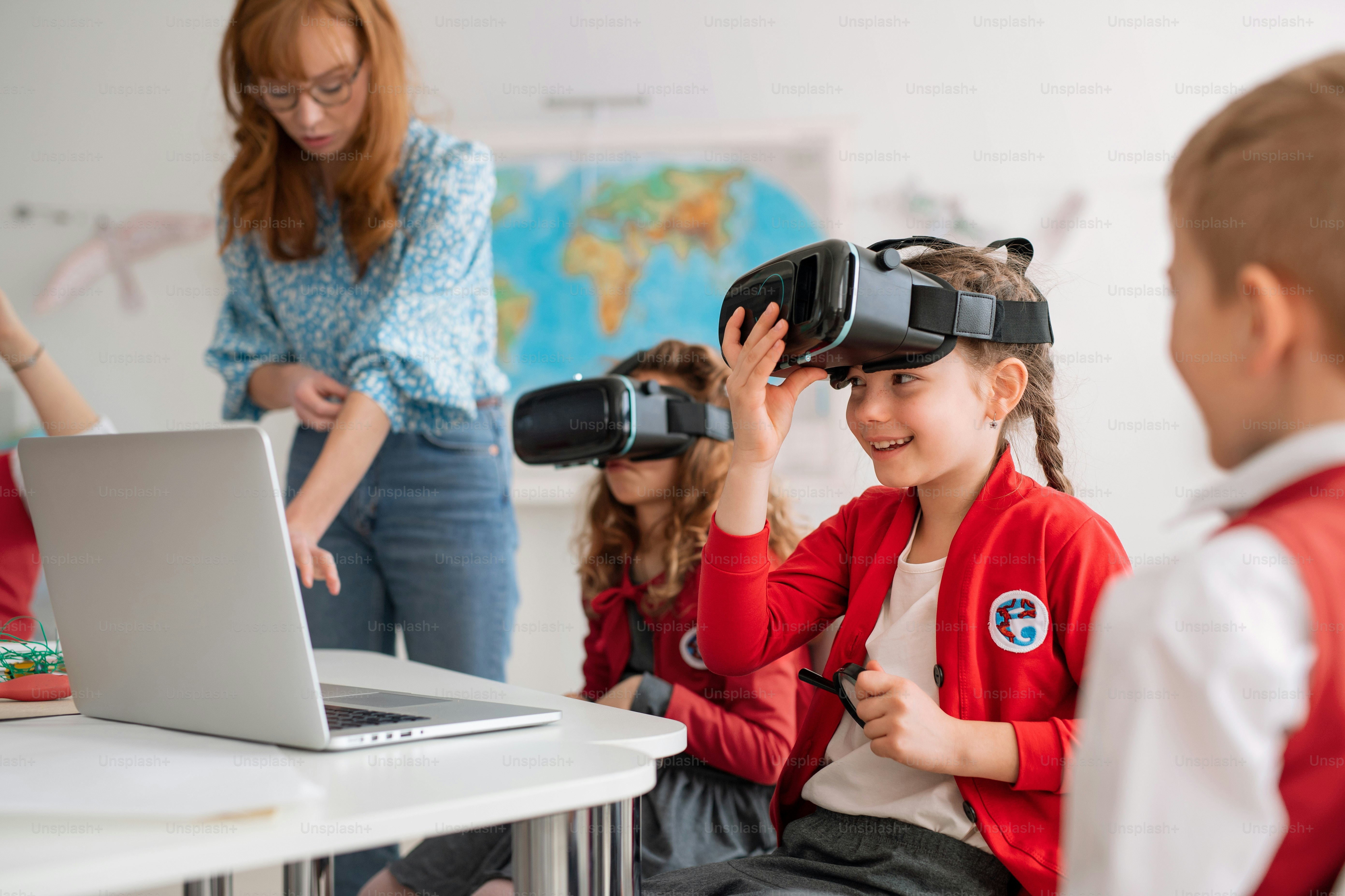 Happy schoolchildren wearing a virtual reality goggles at school in ...
