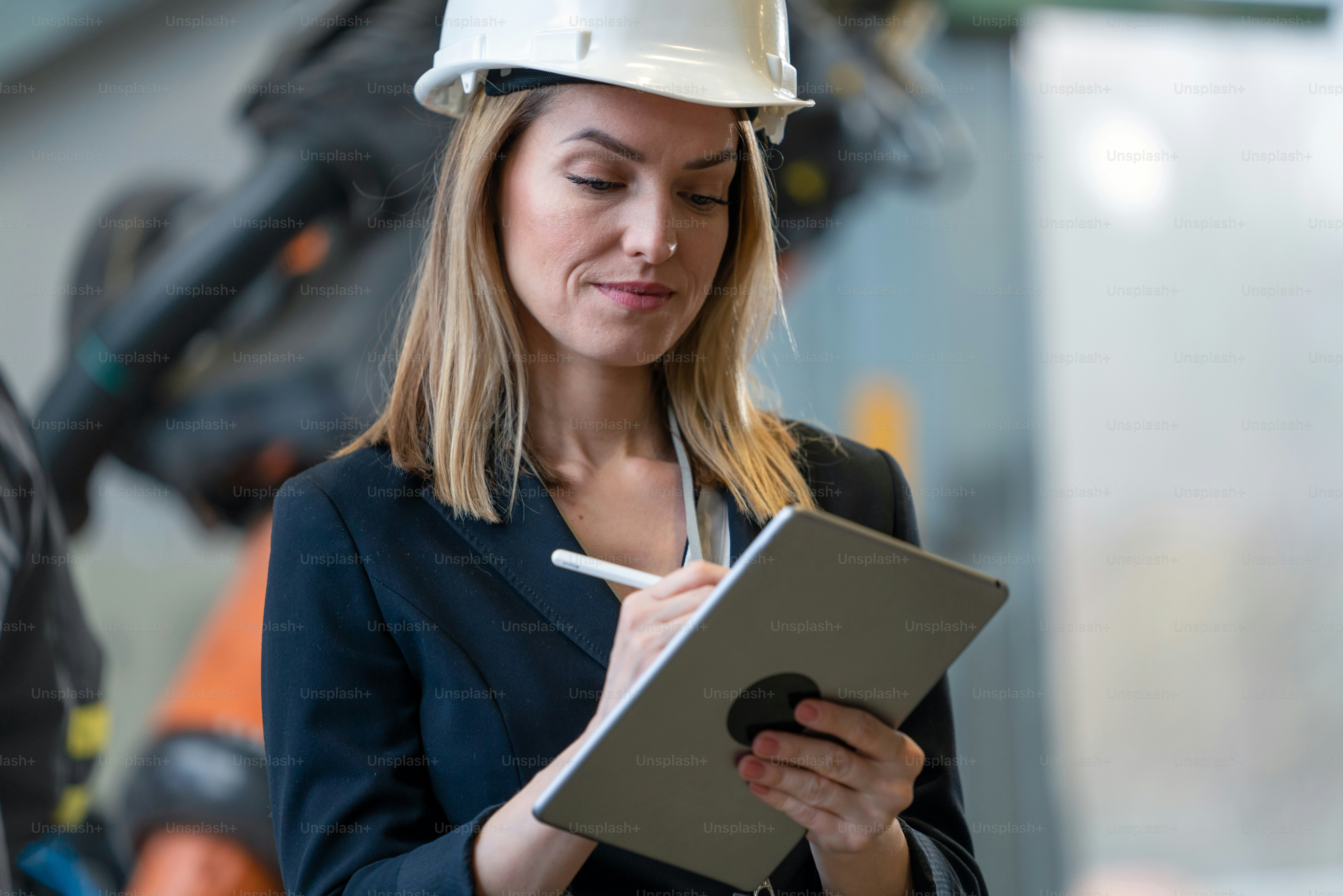 A portrait of female chief engineer in modern industrial factory using ...