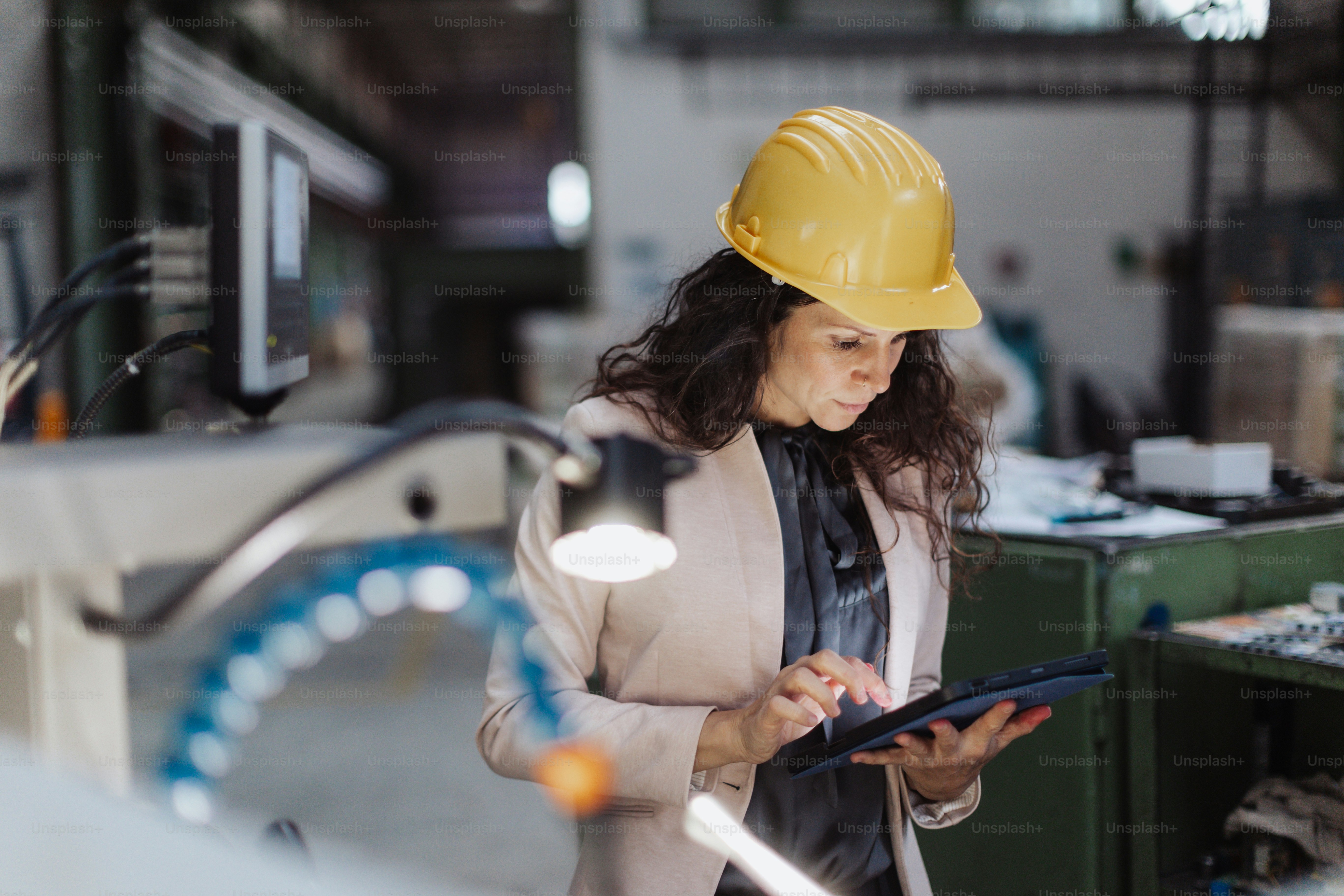 A portrait of female chief engineer in modern industrial factory using ...