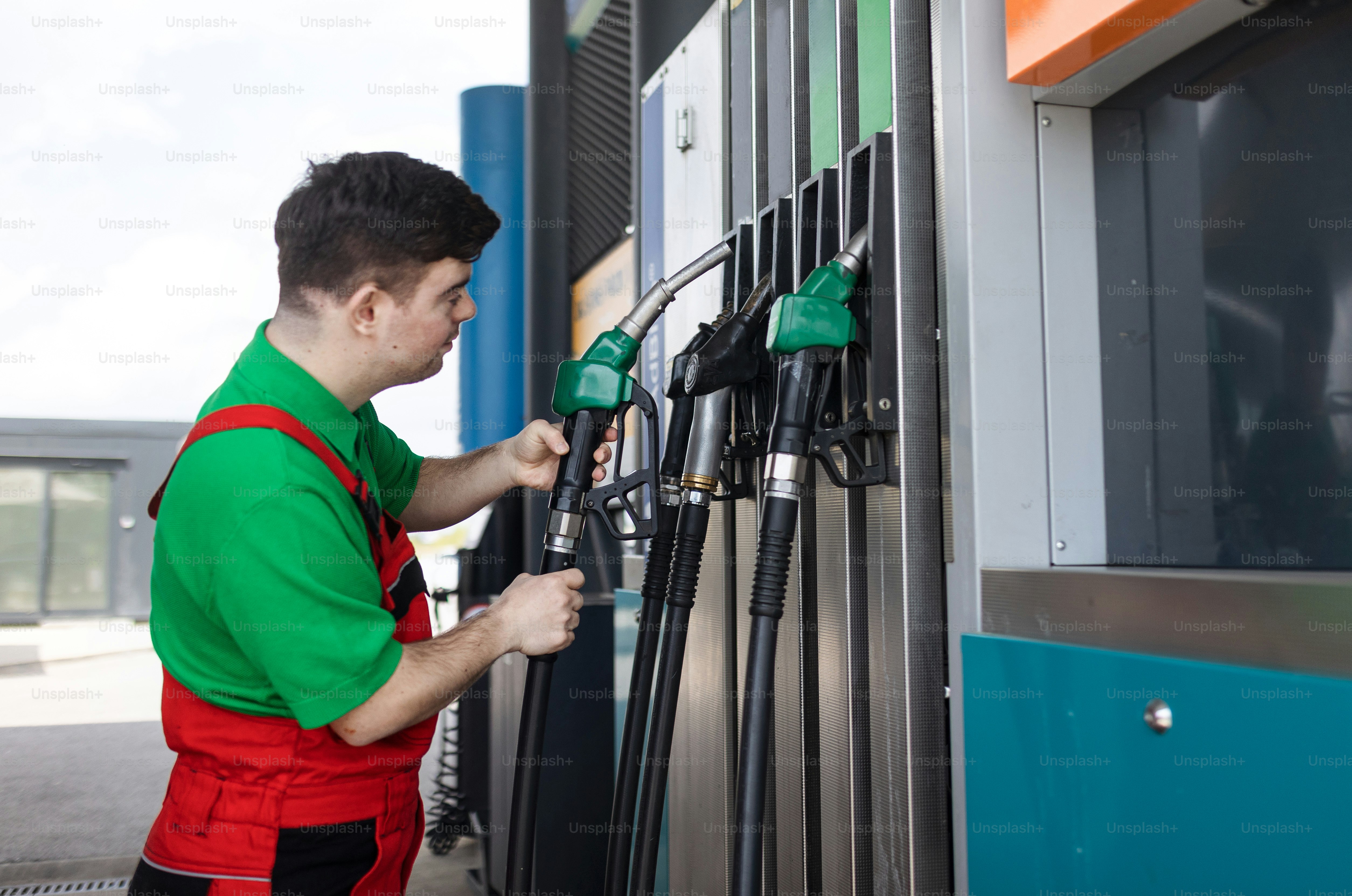A Down syndrome man employee fueling car at gas station. photo – Car ...