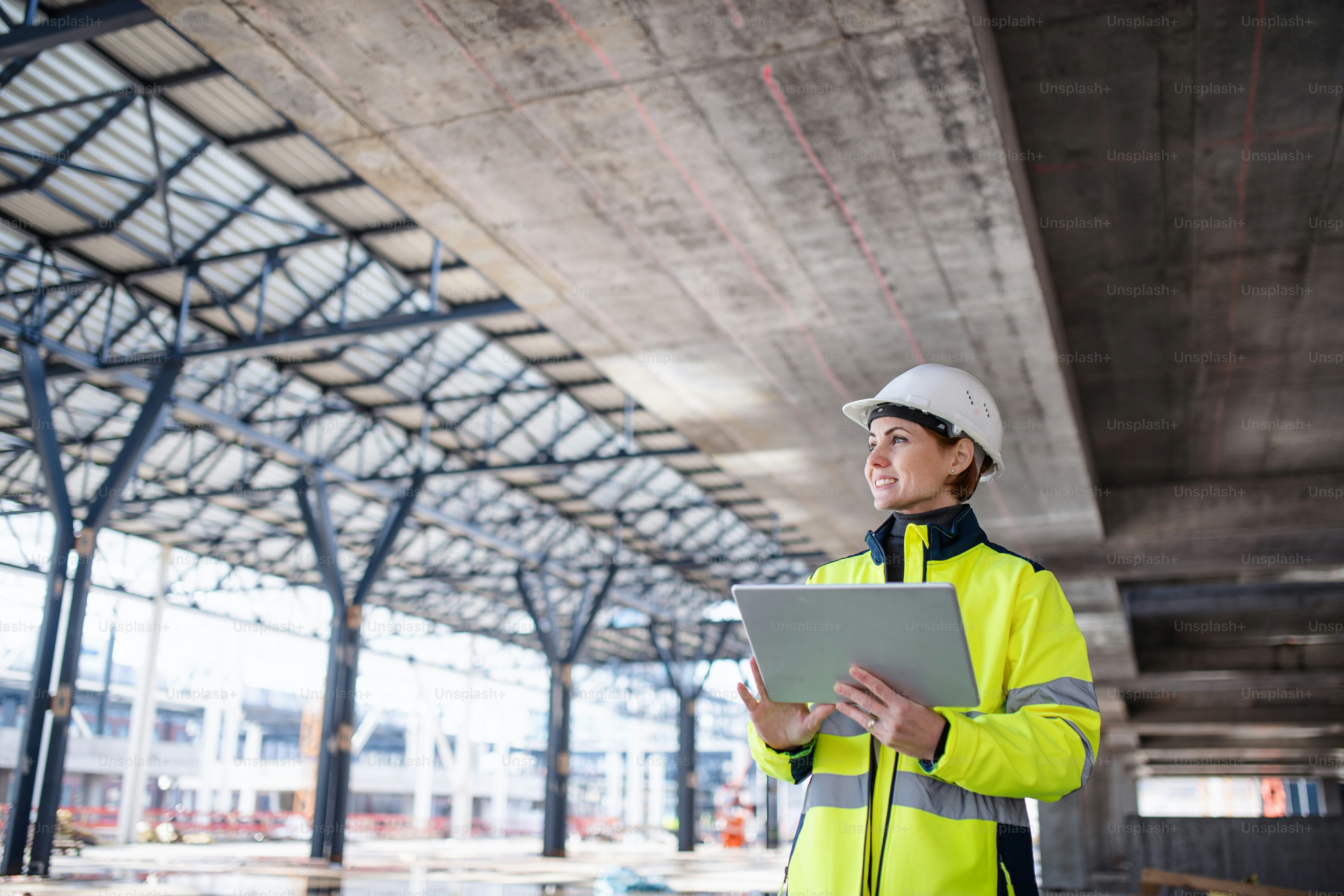 Front view of man engineer with walkie talkie standing on construction ...