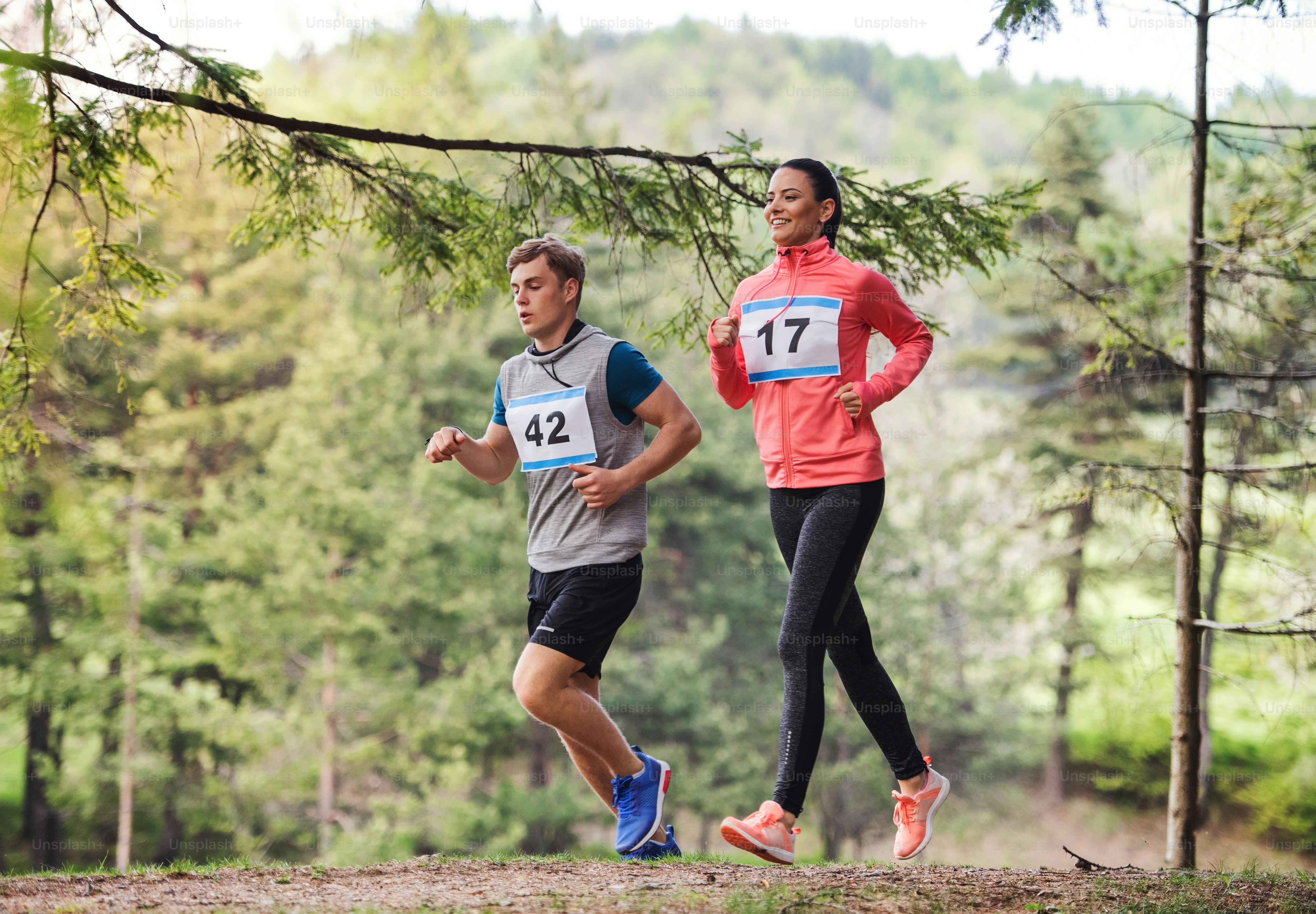 Active young couple running a race competition in nature. photo ...