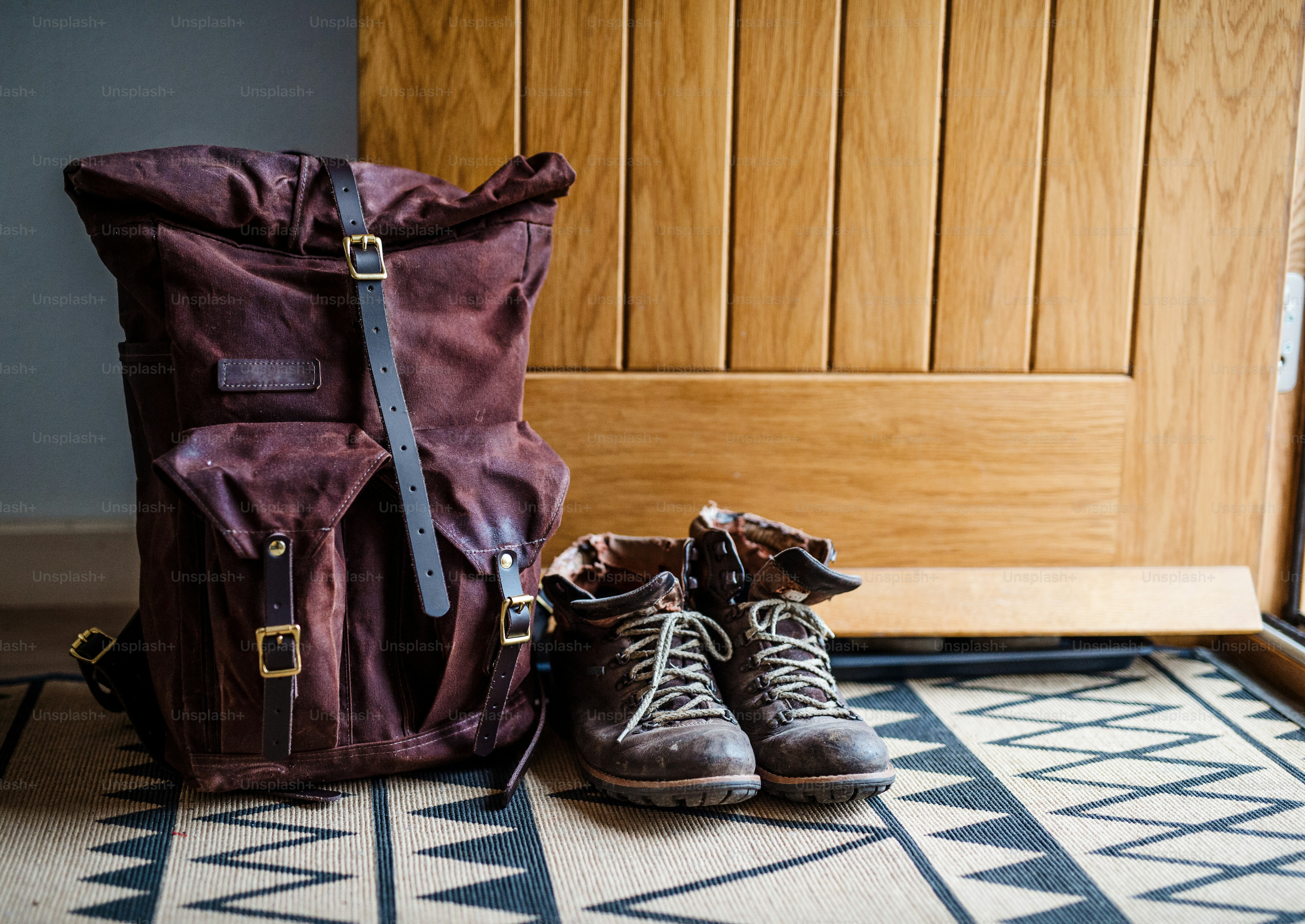 Pair of boots and backpack by open front door. Copy space. photo ...