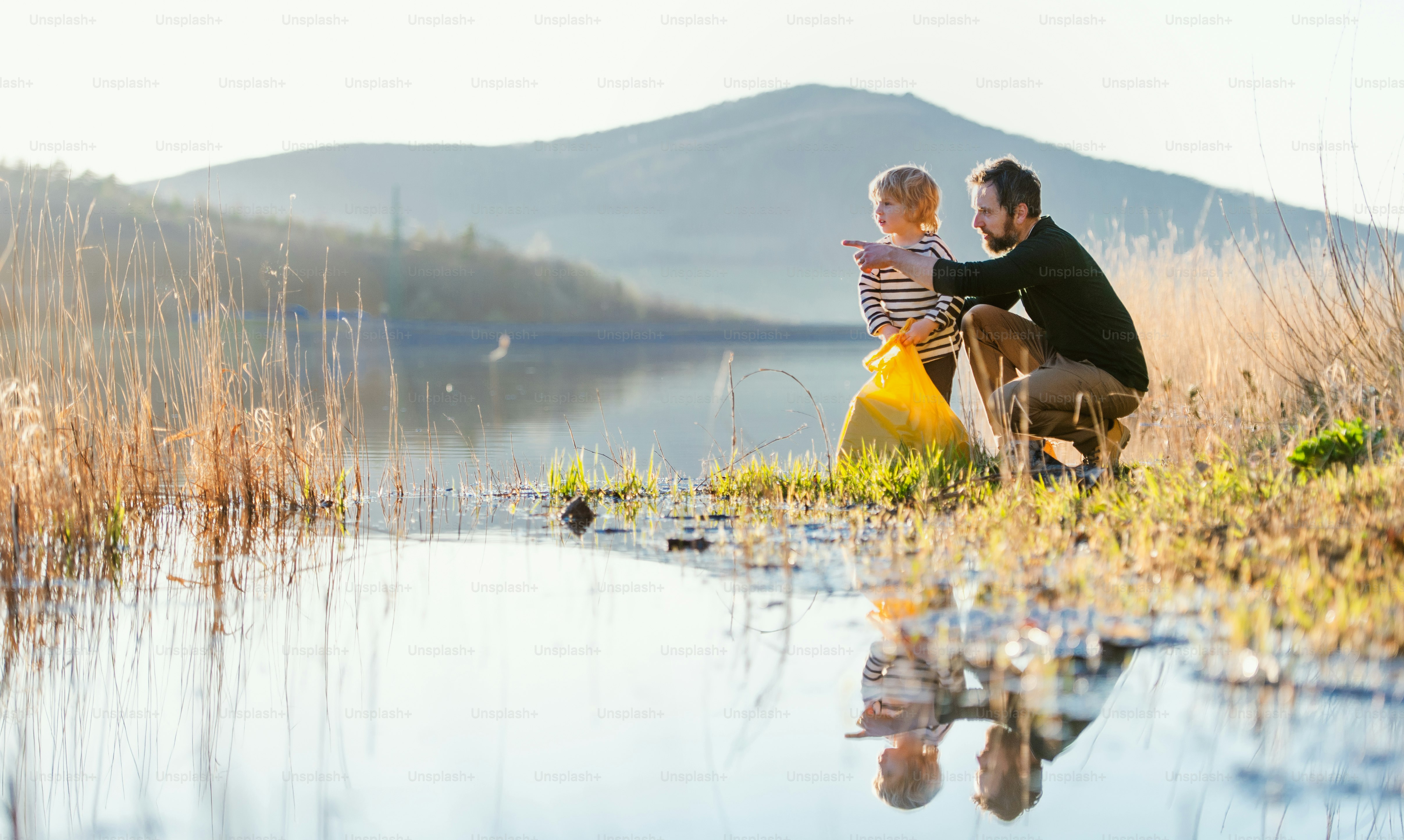 Mature father with small children working outdoors in garden ...