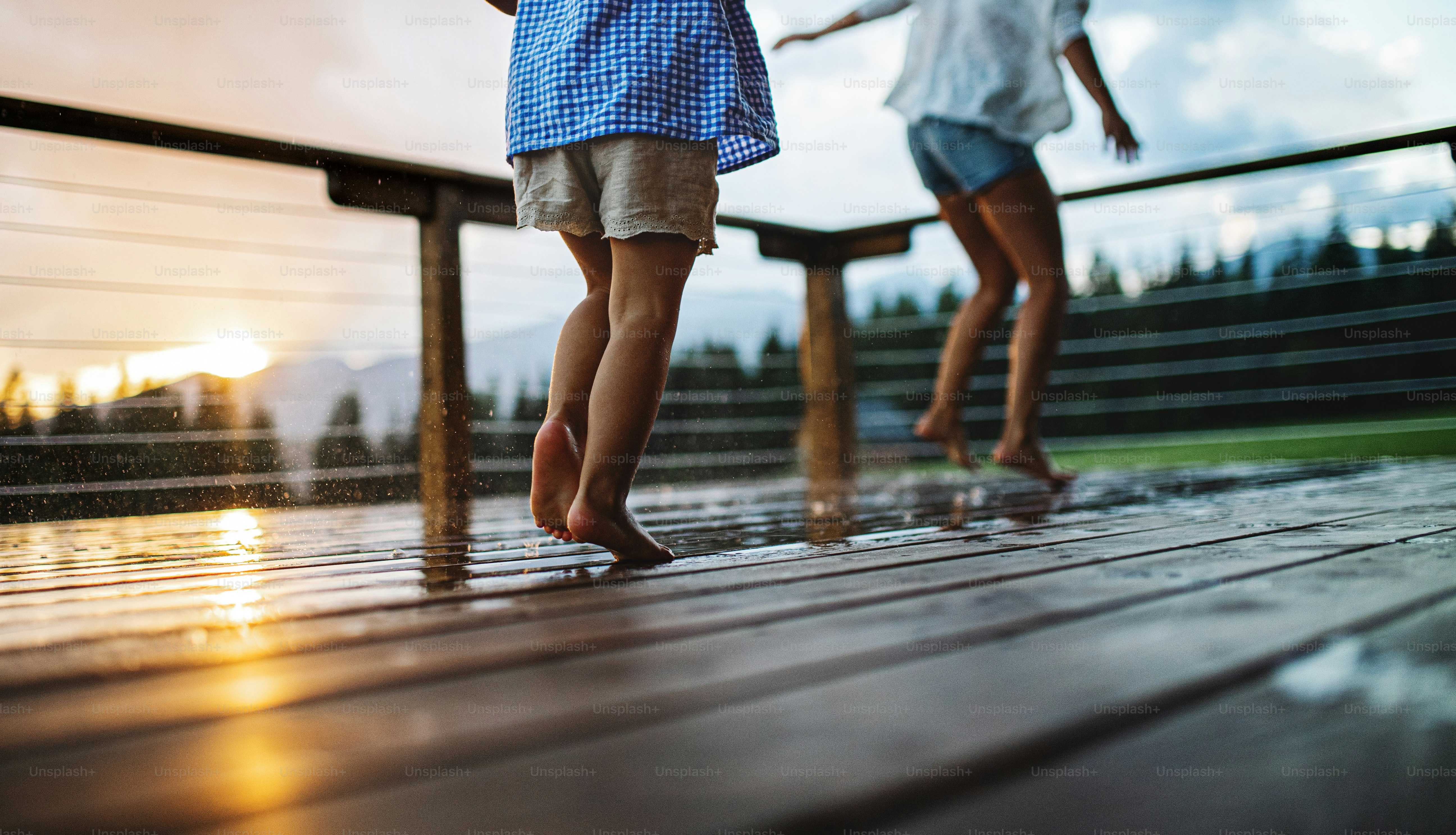 Legs of unrecognizable mother with small daughter playing on patio of ...