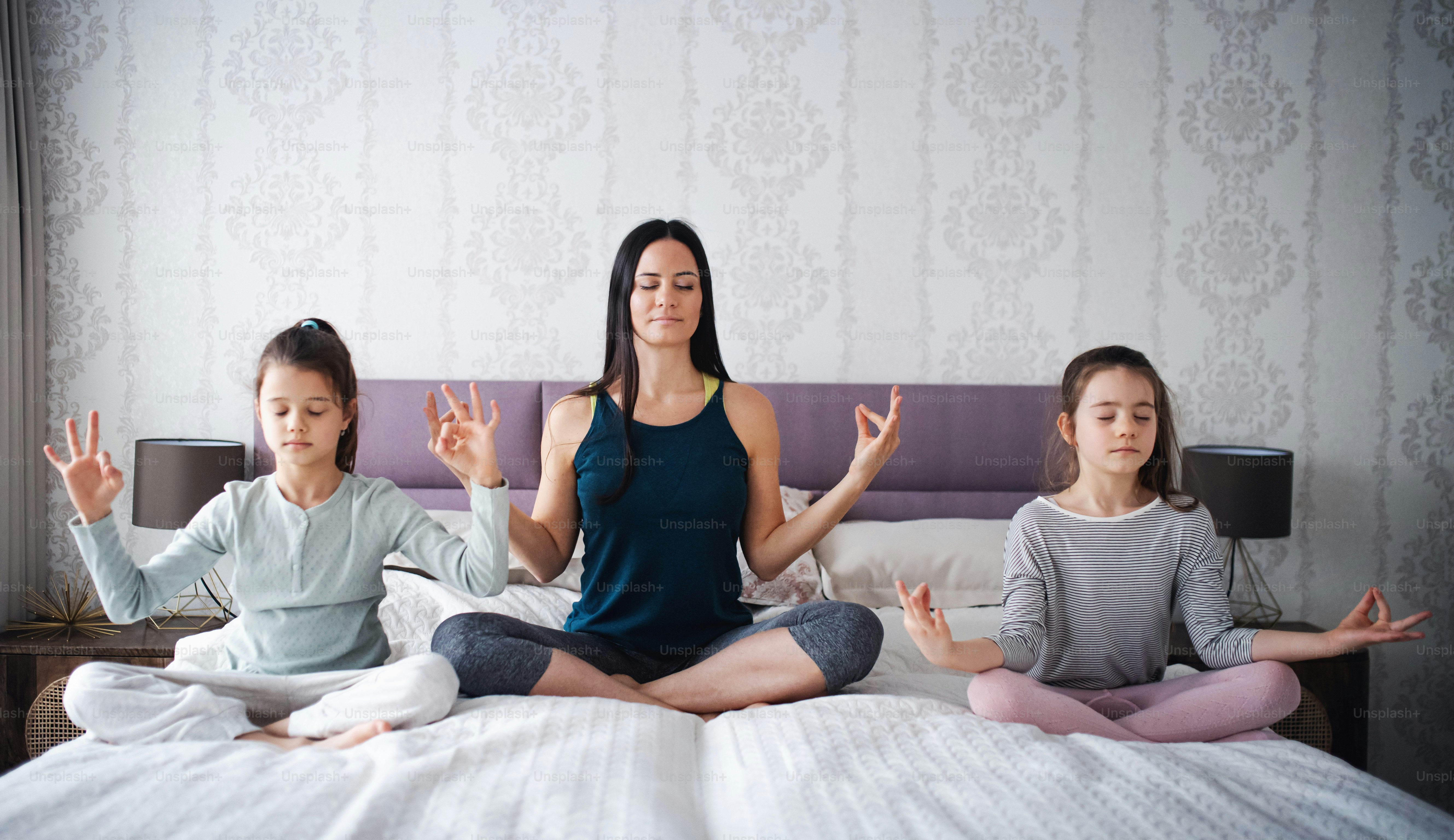 Portrait of mother with daughters doing yoga meditation exercise ...