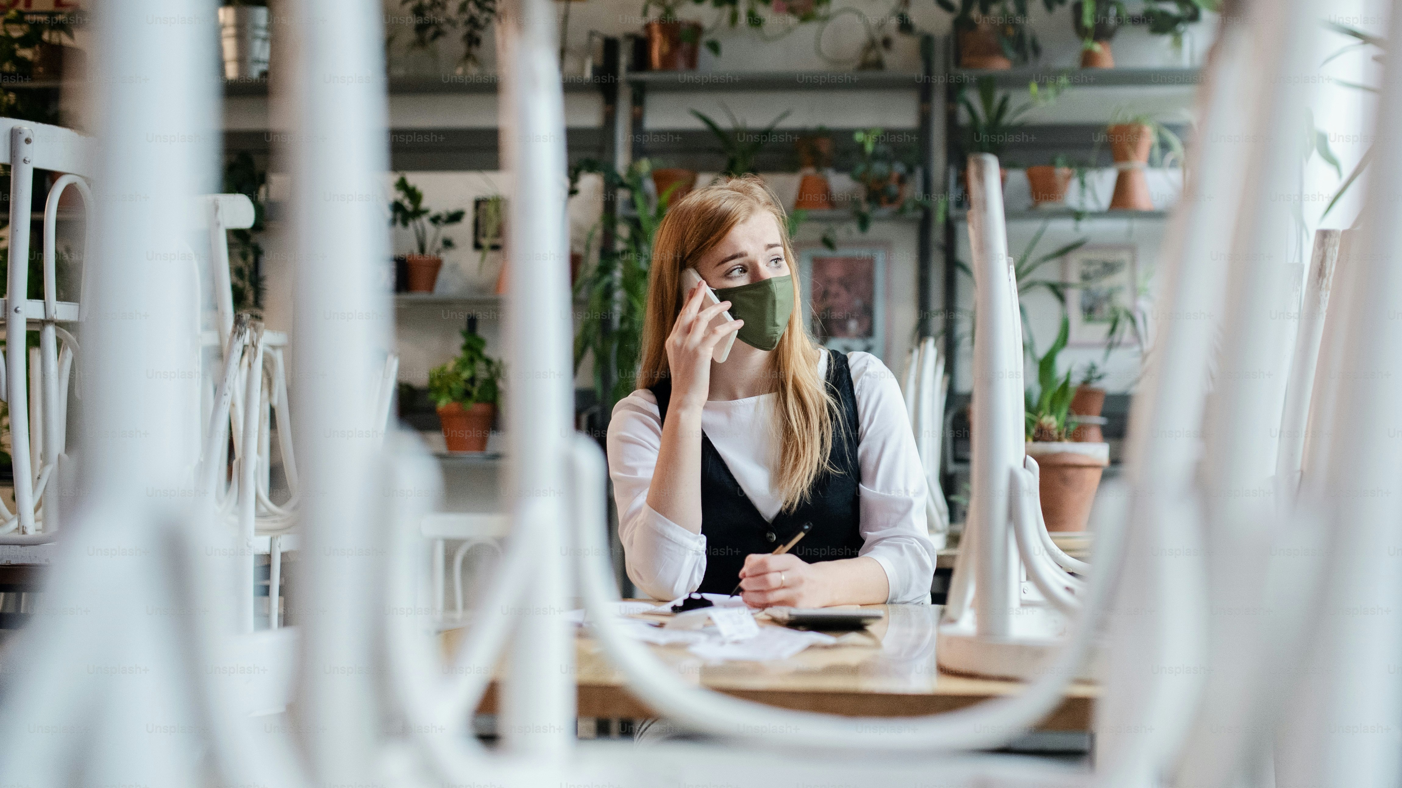 Frustrated owner sitting at table in closed cafe or coffee shop, small ...