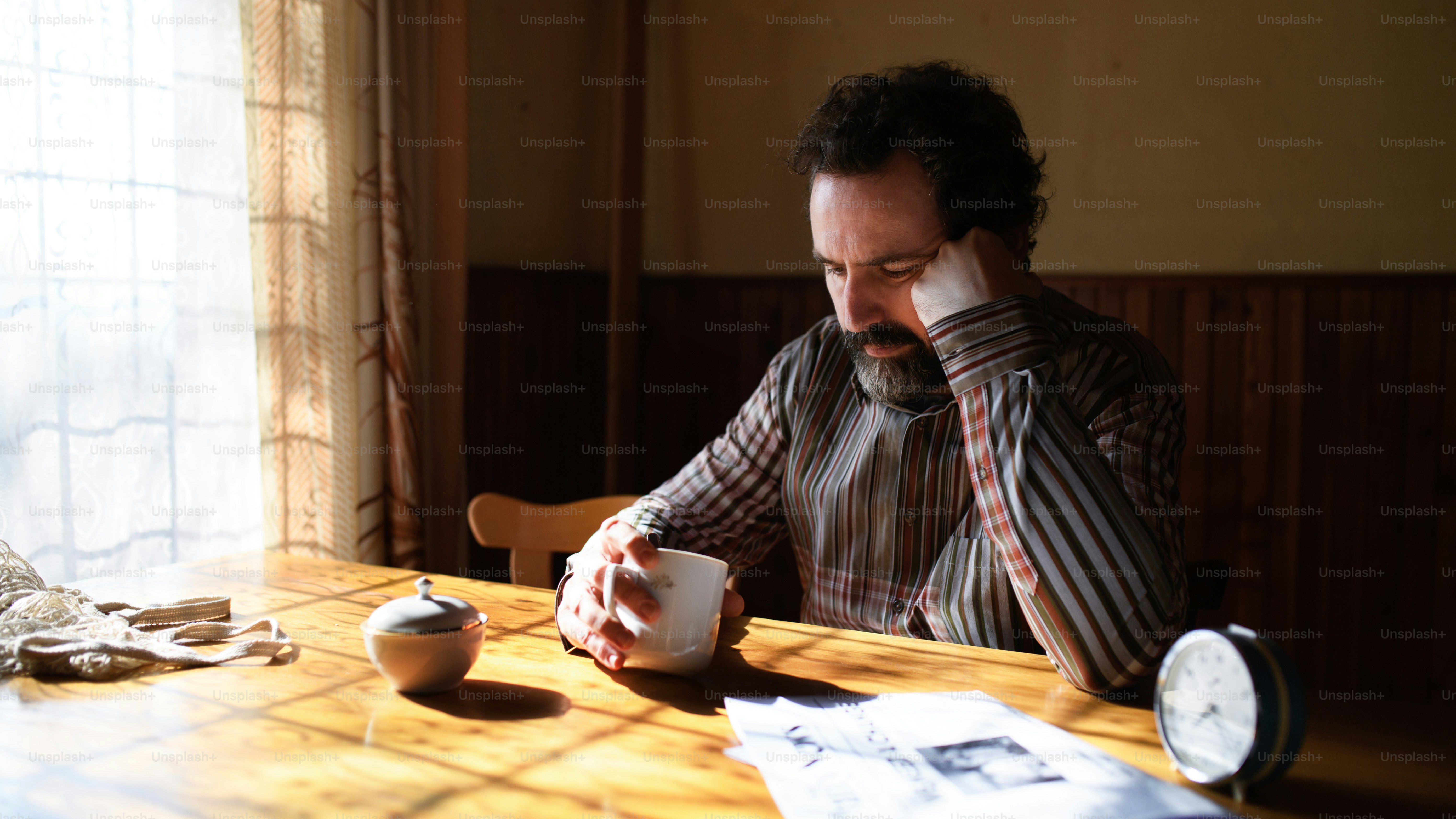 Retrato de um pobre e infeliz homem maduro com café lendo jornais ...