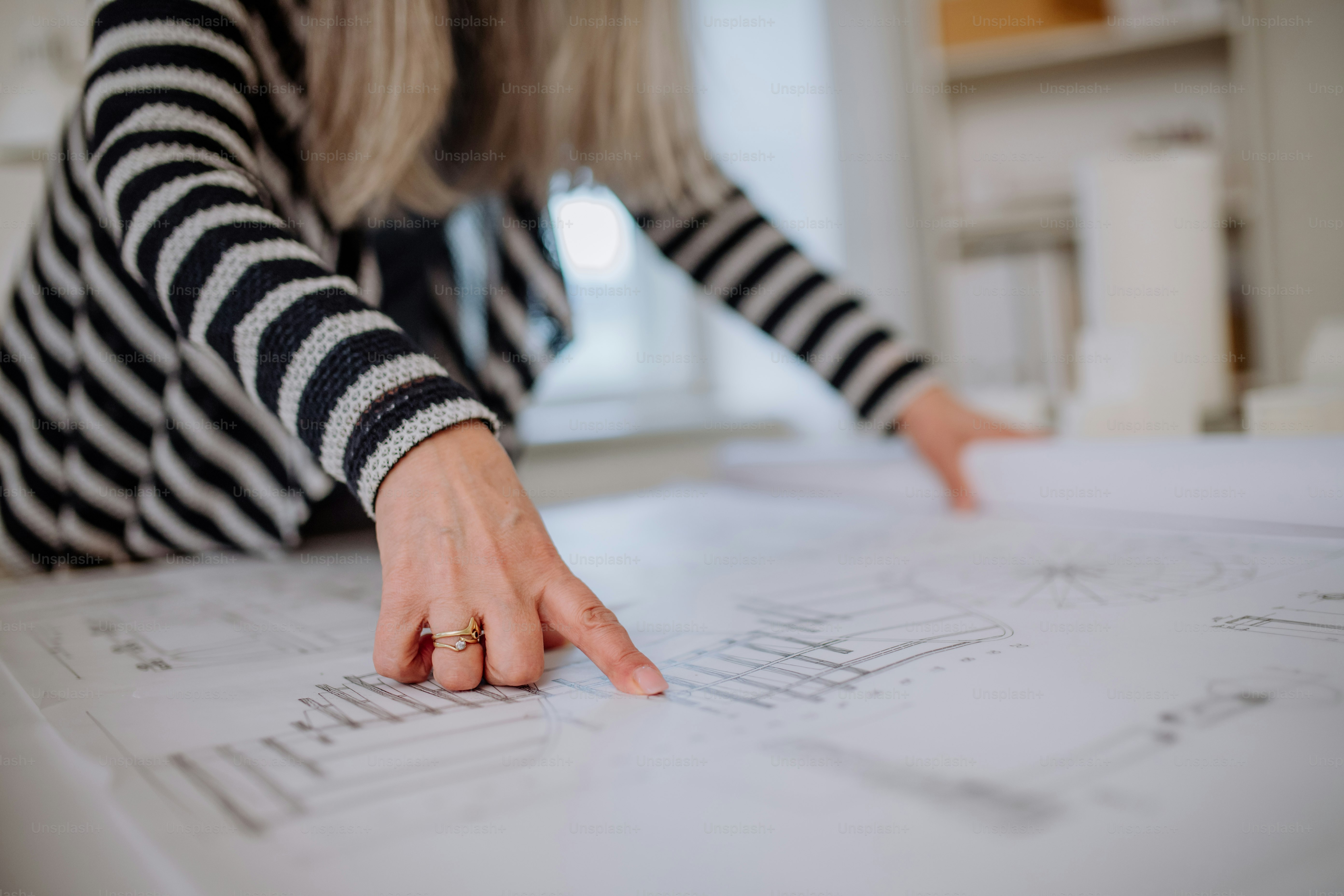 A close-up of woman architect looking at blueprints in office. photo ...