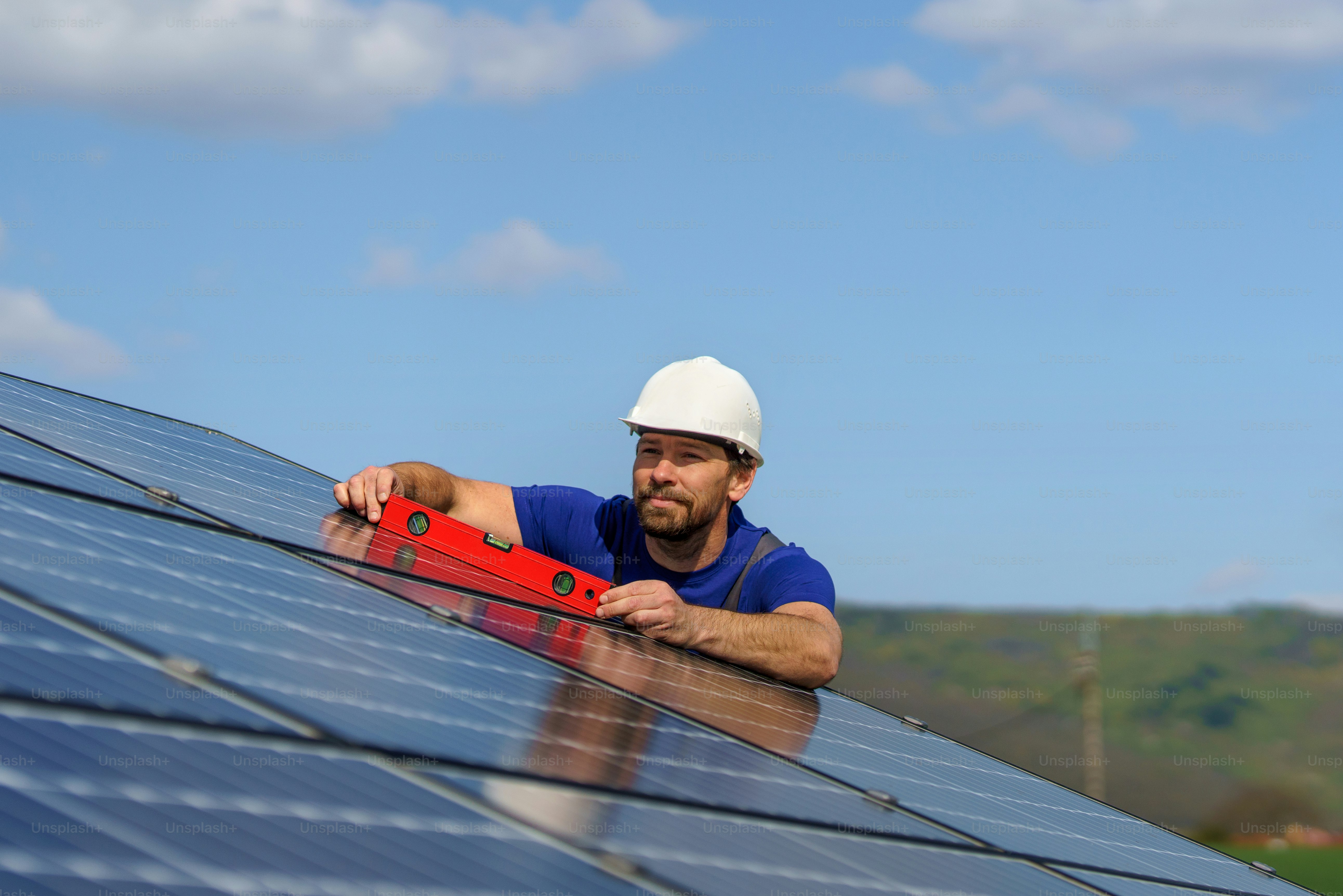 A man worker installing solar photovoltaic panels on roof, alternative ...