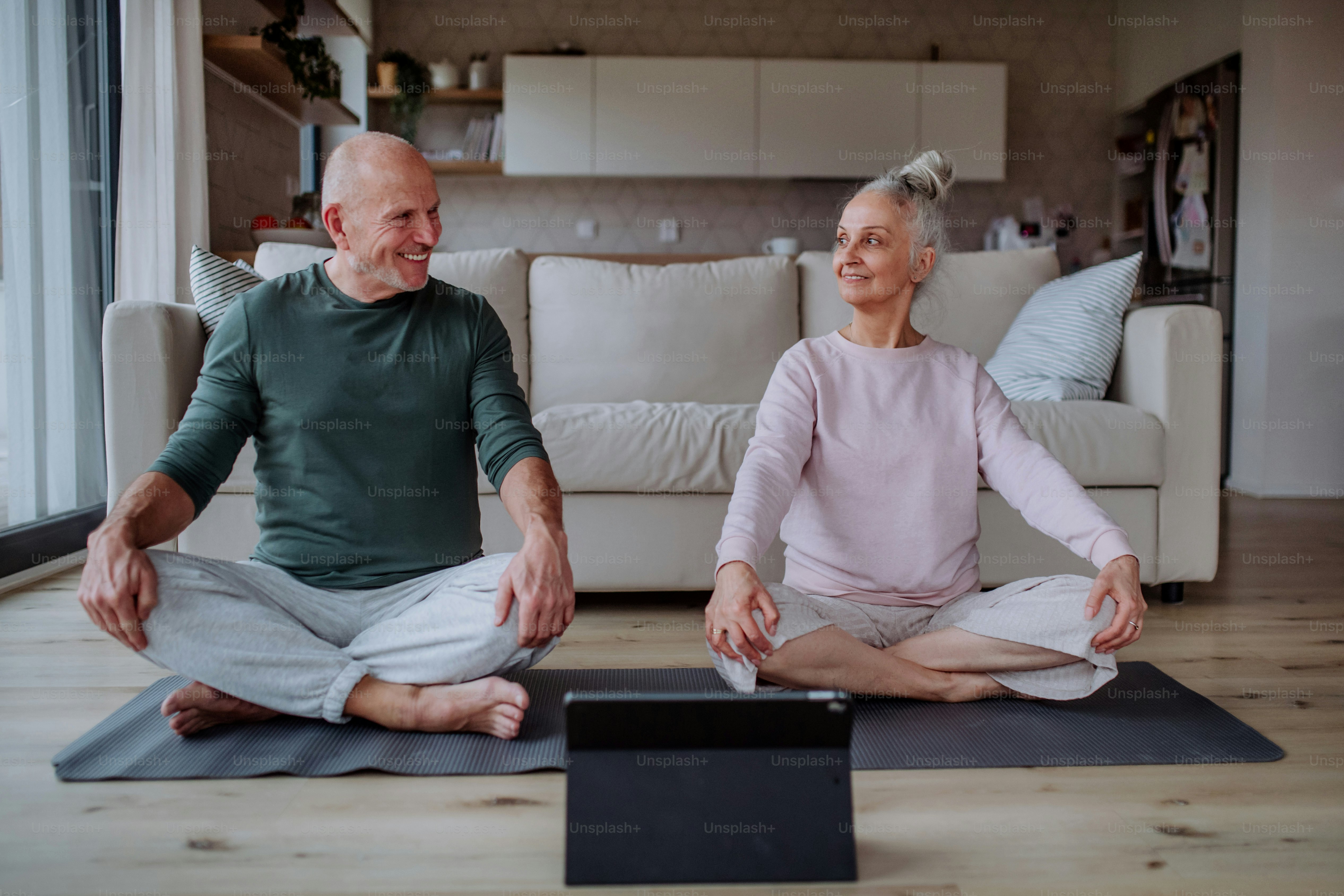A senior couple doing relaxation exercise together at home. photo ...
