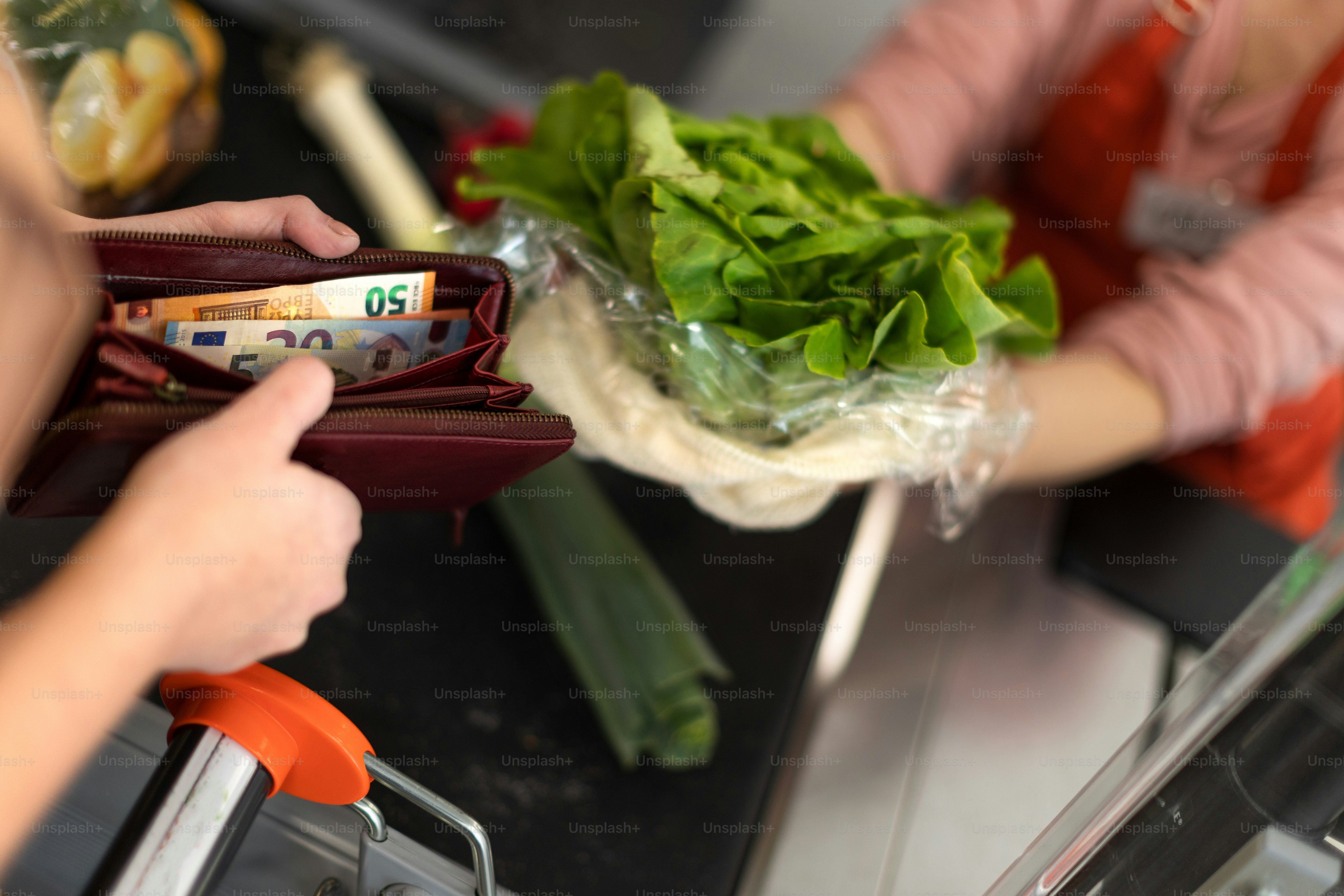 A close-up of woman giving money at the cash desk in supermarket photo ...
