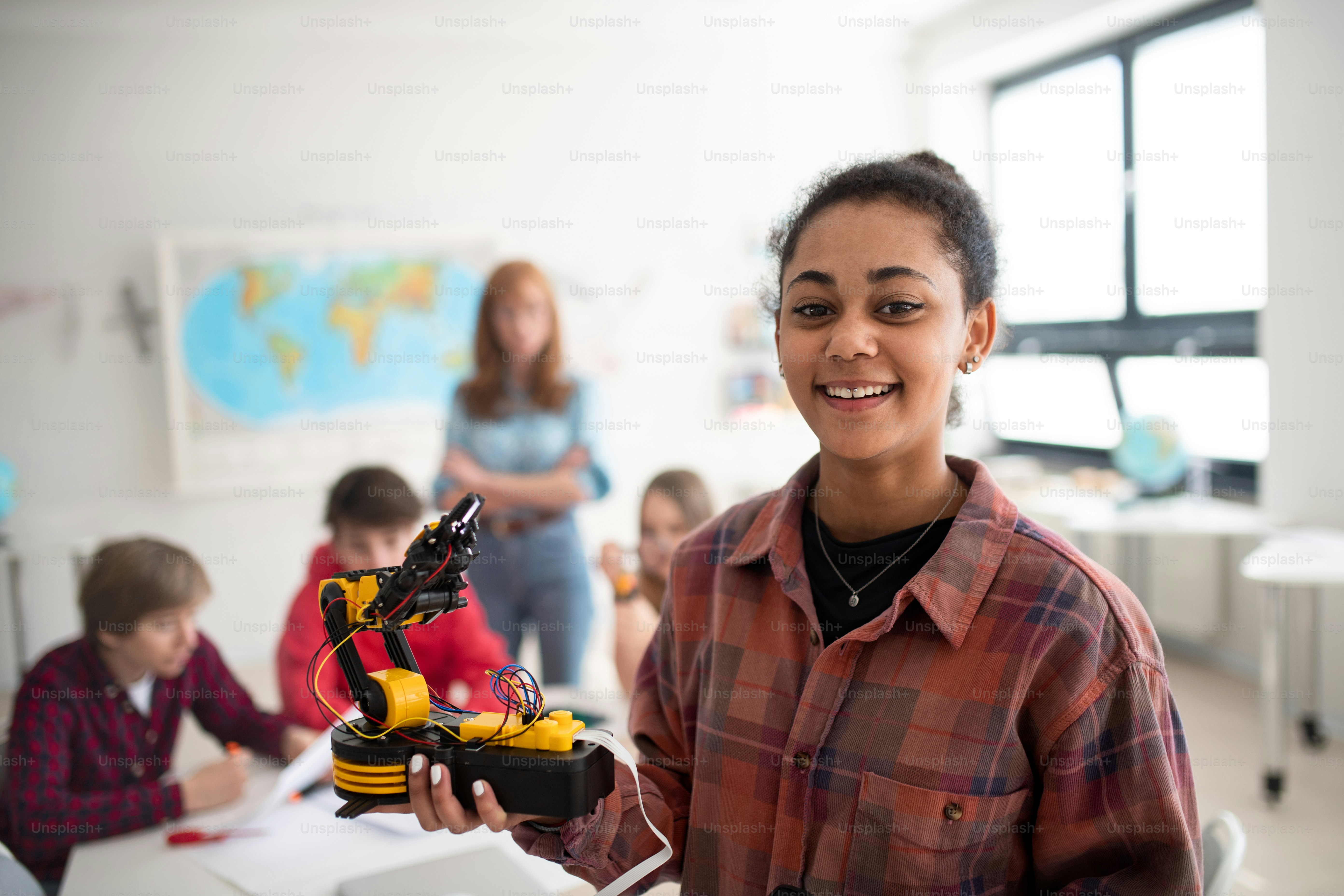 A college student holding her robotic toy at robotics classroom at ...