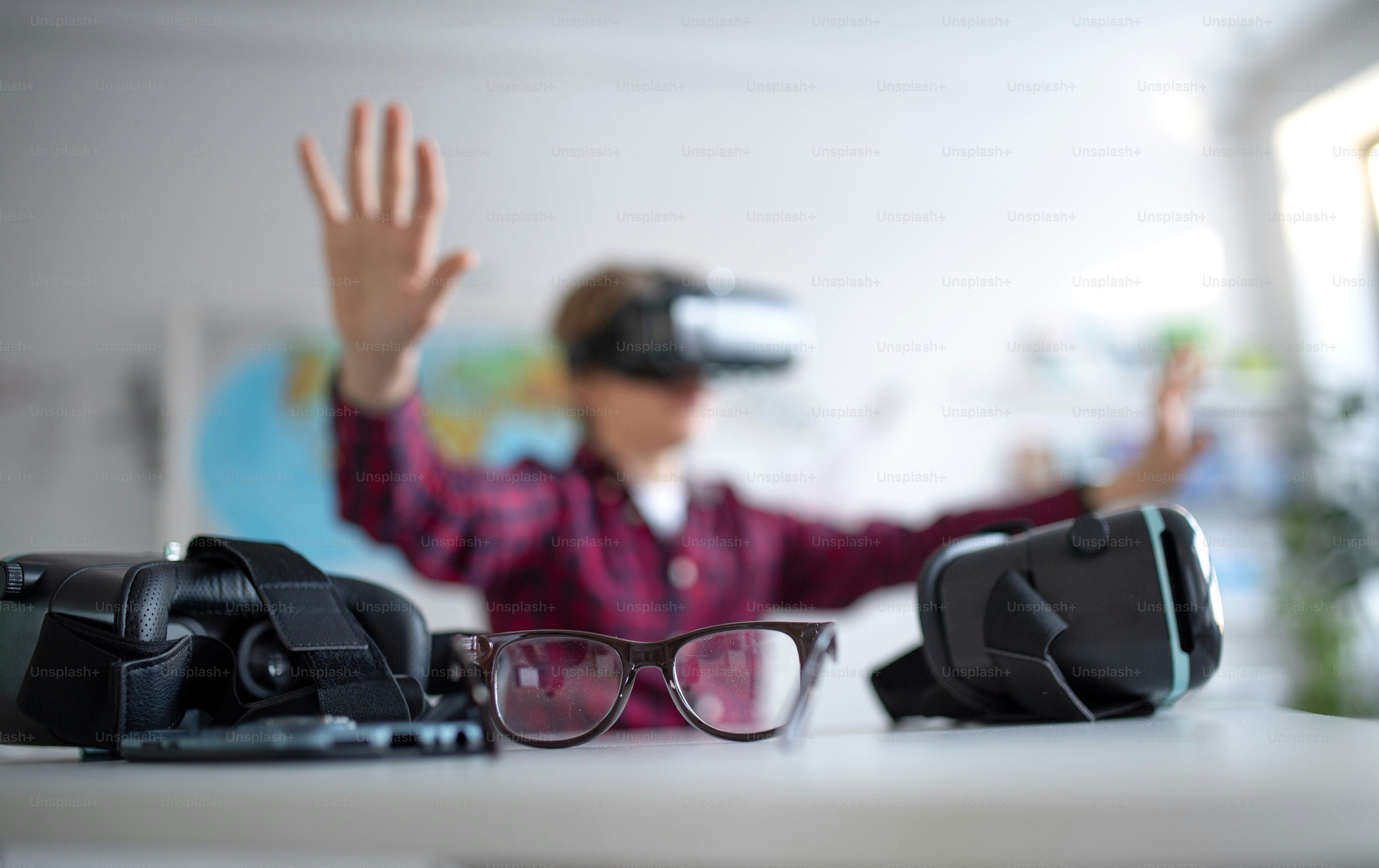 A happy student wearing virtual reality goggles at school in computer ...