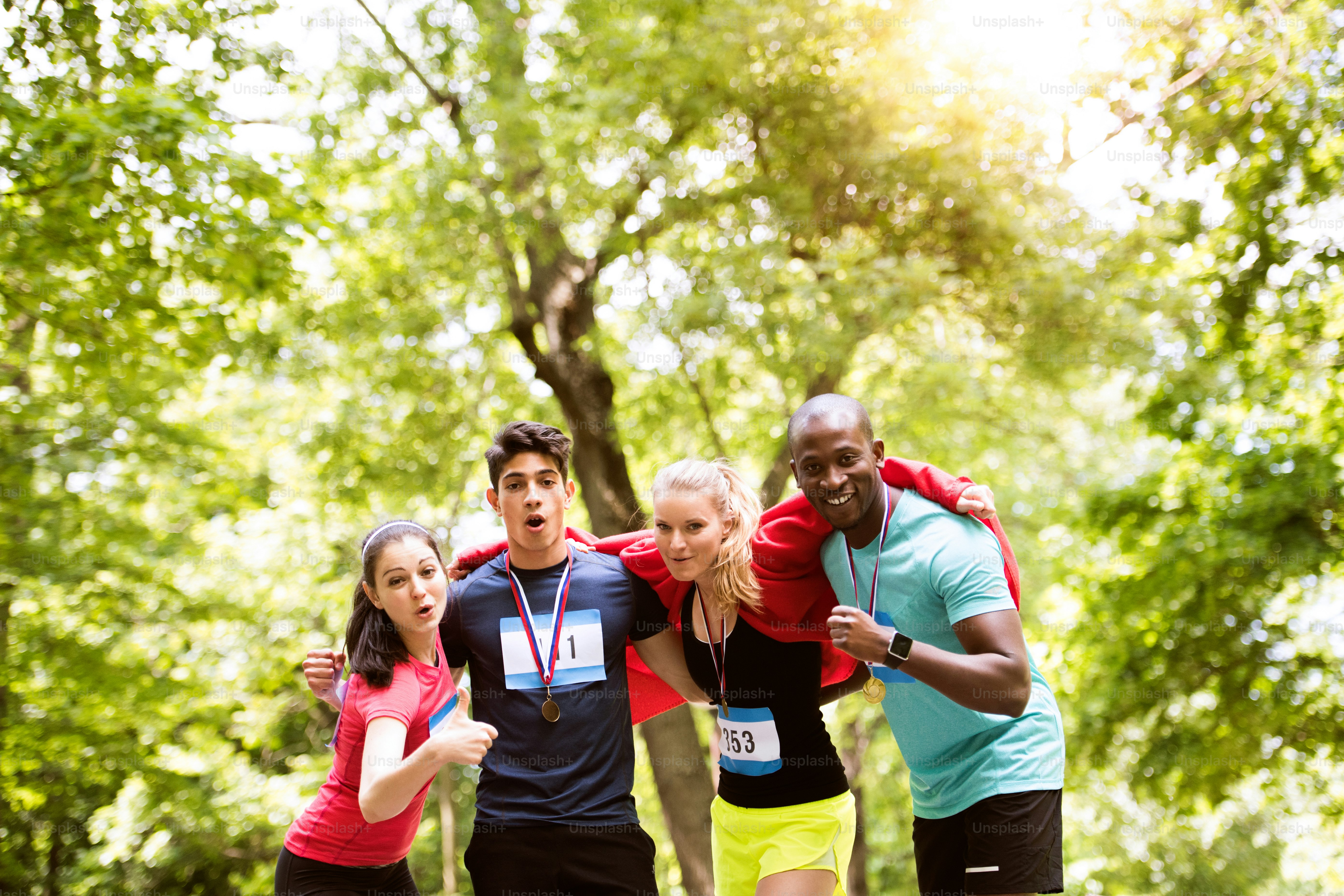 Group of young fit friends at the finish line happy after completing ...