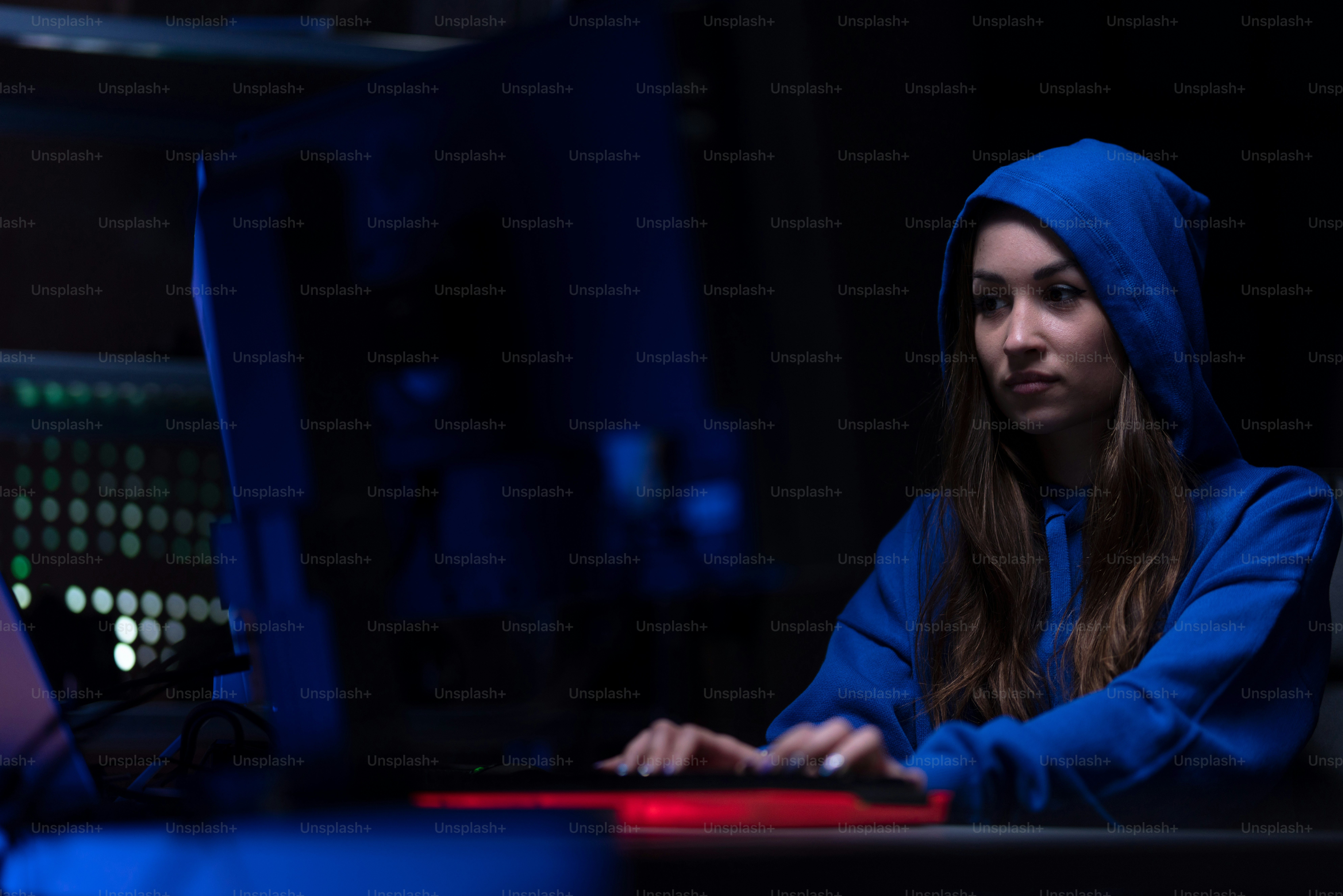 Close-up of a woman hacker hands at keyboard computer in the dark room ...
