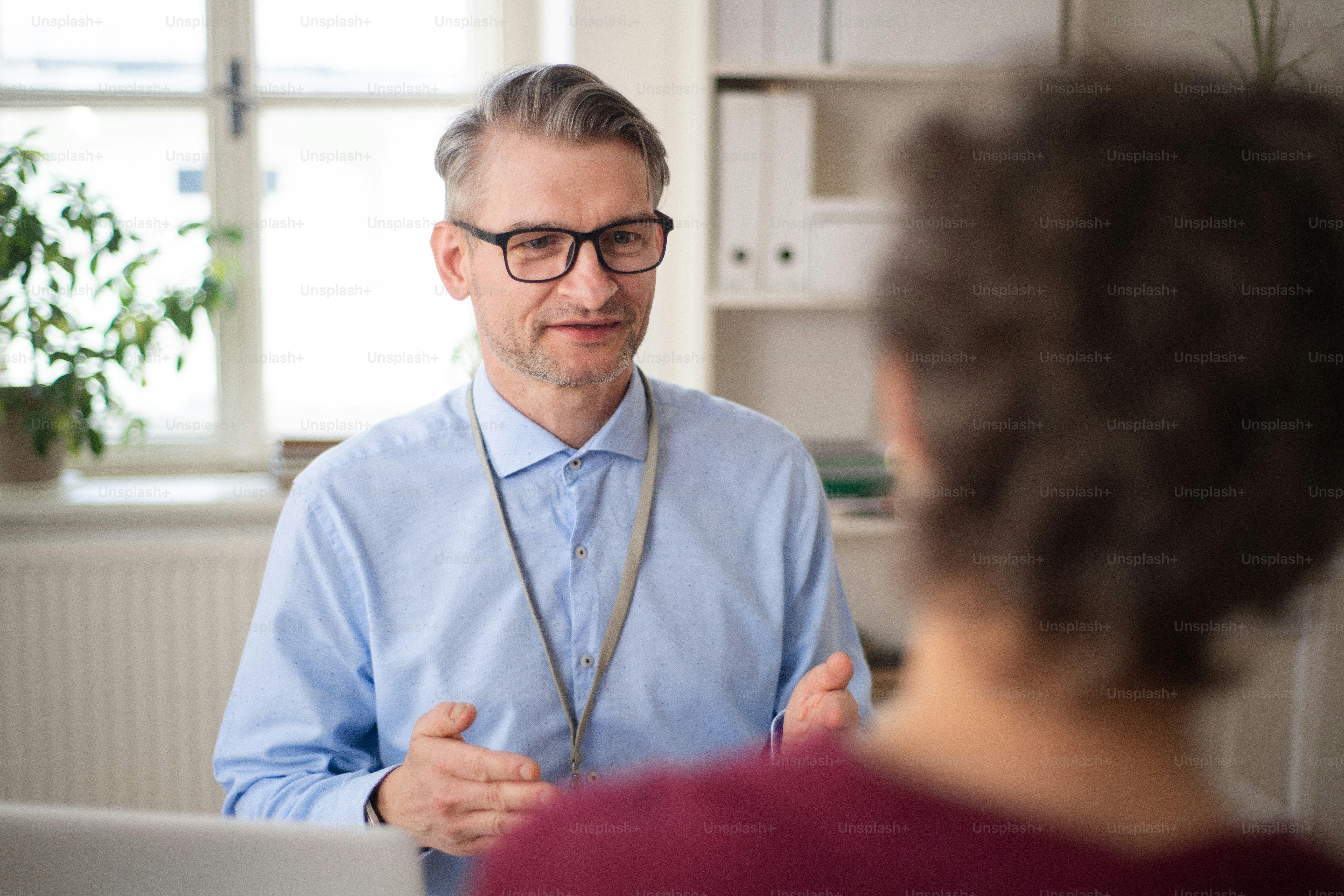 A mature man recruiter explayining something young candidate during the ...
