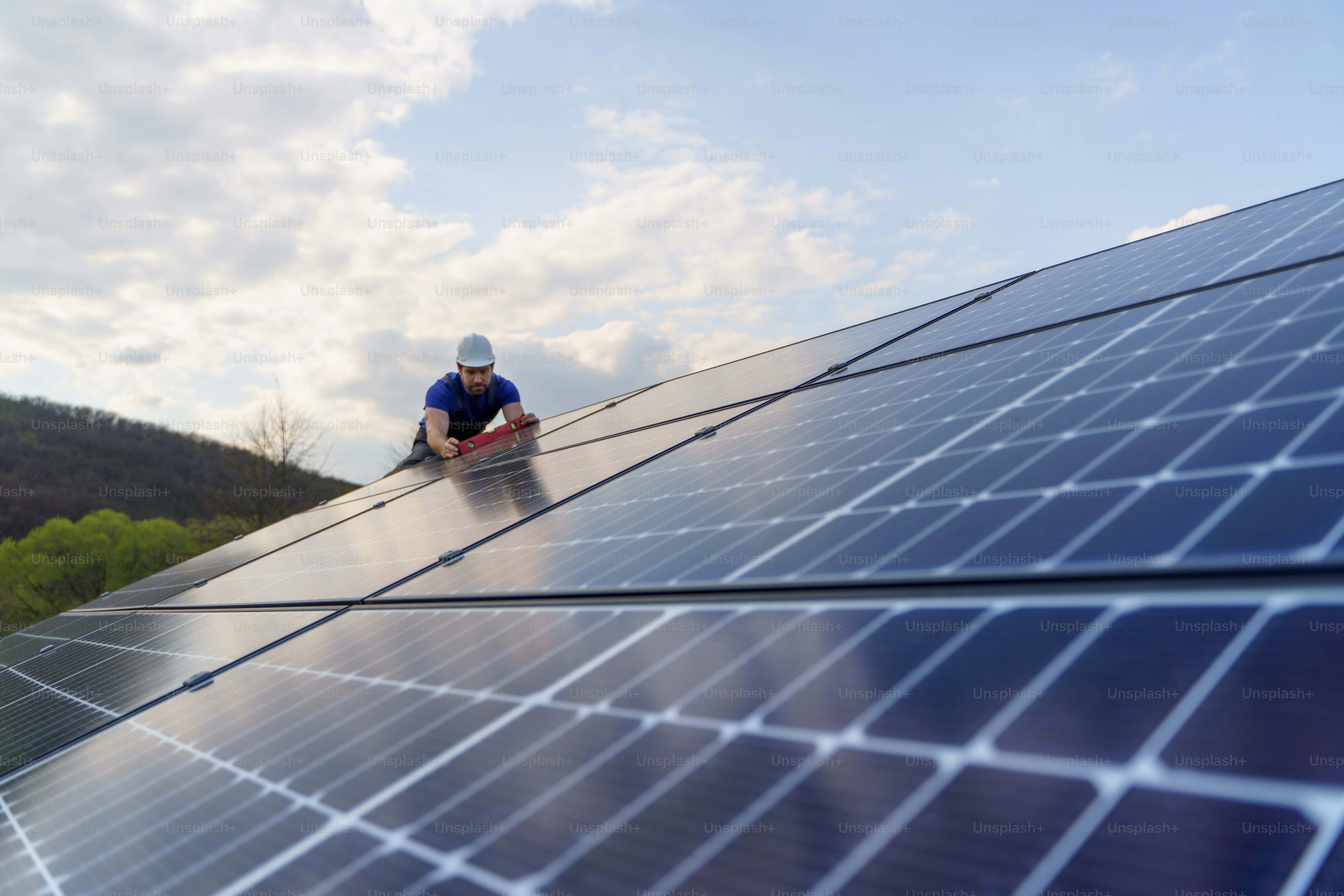 A man worker installing solar photovoltaic panels on roof, alternative ...