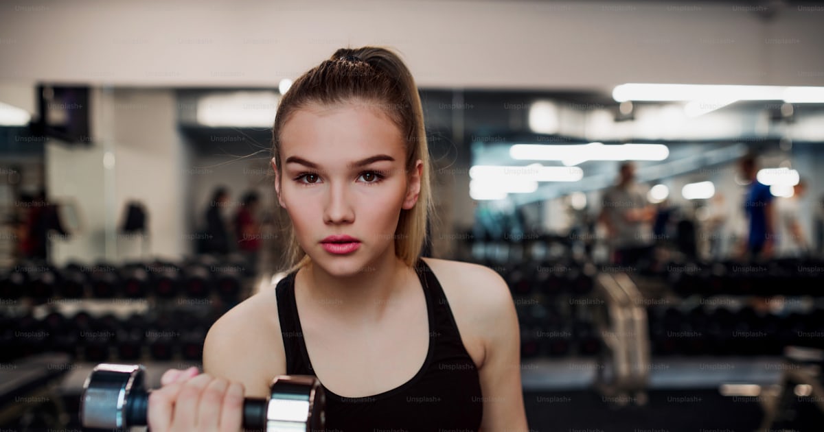 ダンベルを持った若い女の子や女性がジムでトレーニングをしている。の写真 Unsplashの女性アスリートの画像