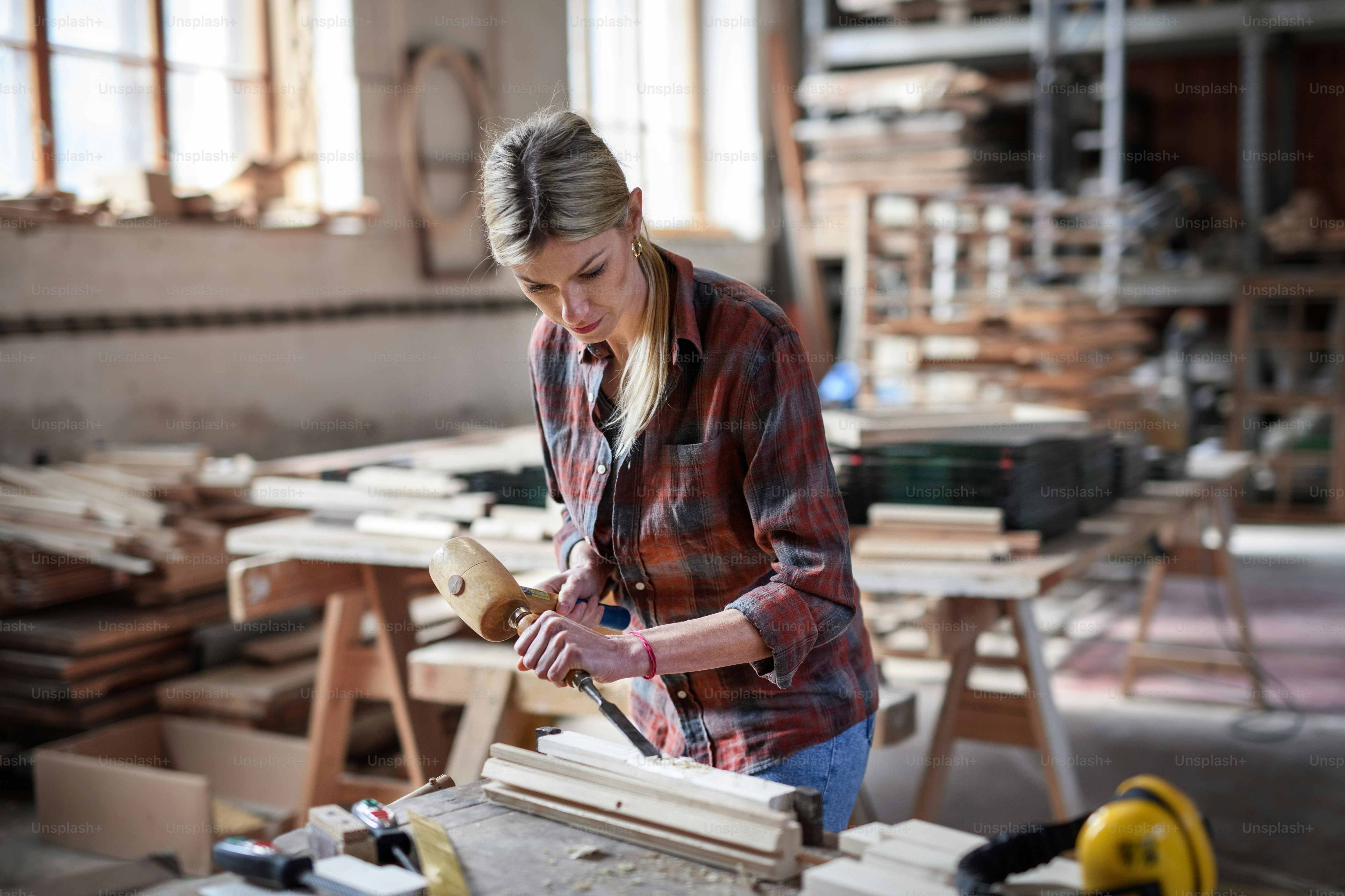A portrait of female carpenter working on her product indoors in carpentry workshop. photo ...