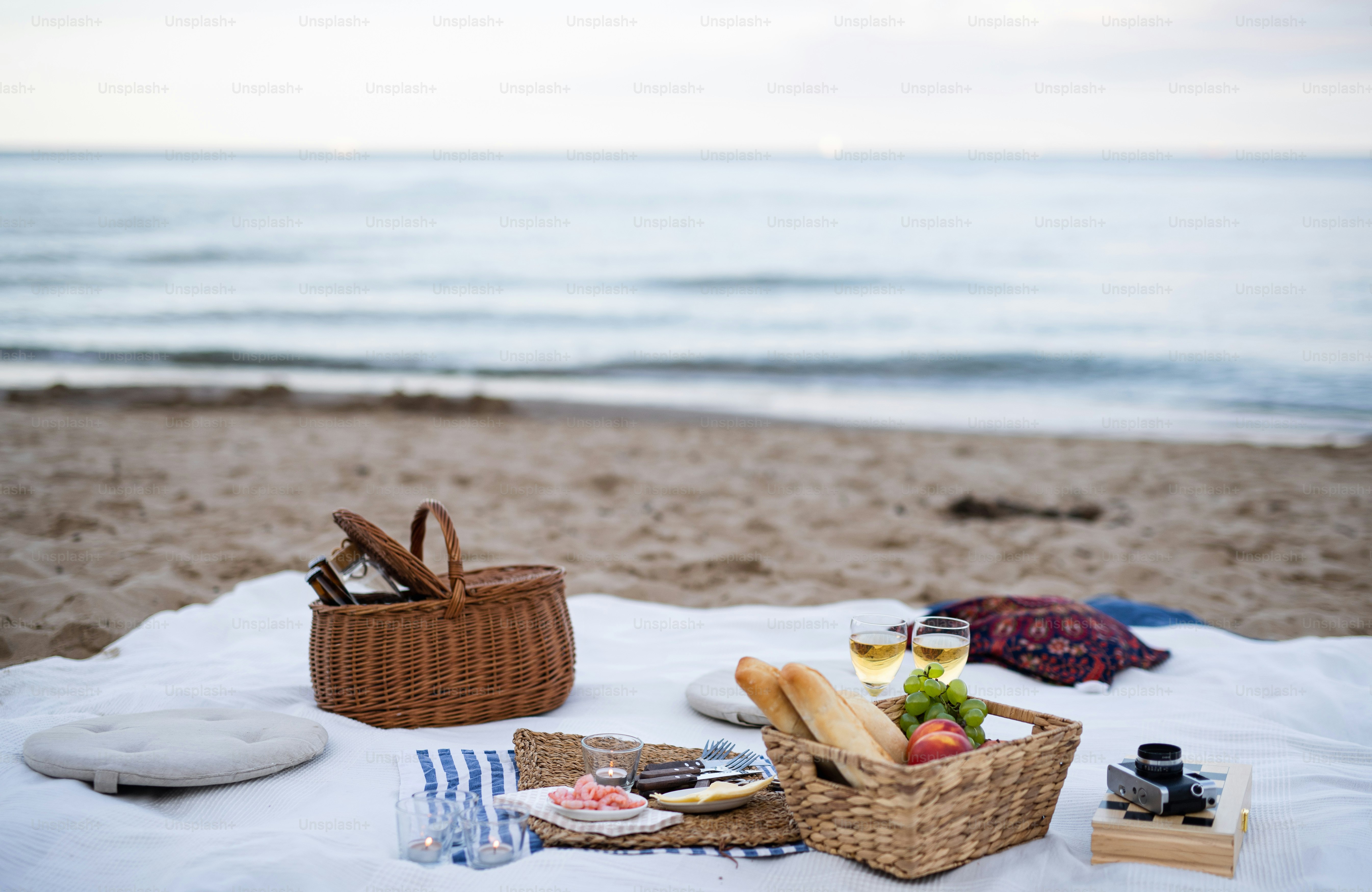 A beach picnic with schripms, beer, candles. photo – Beach Image on ...