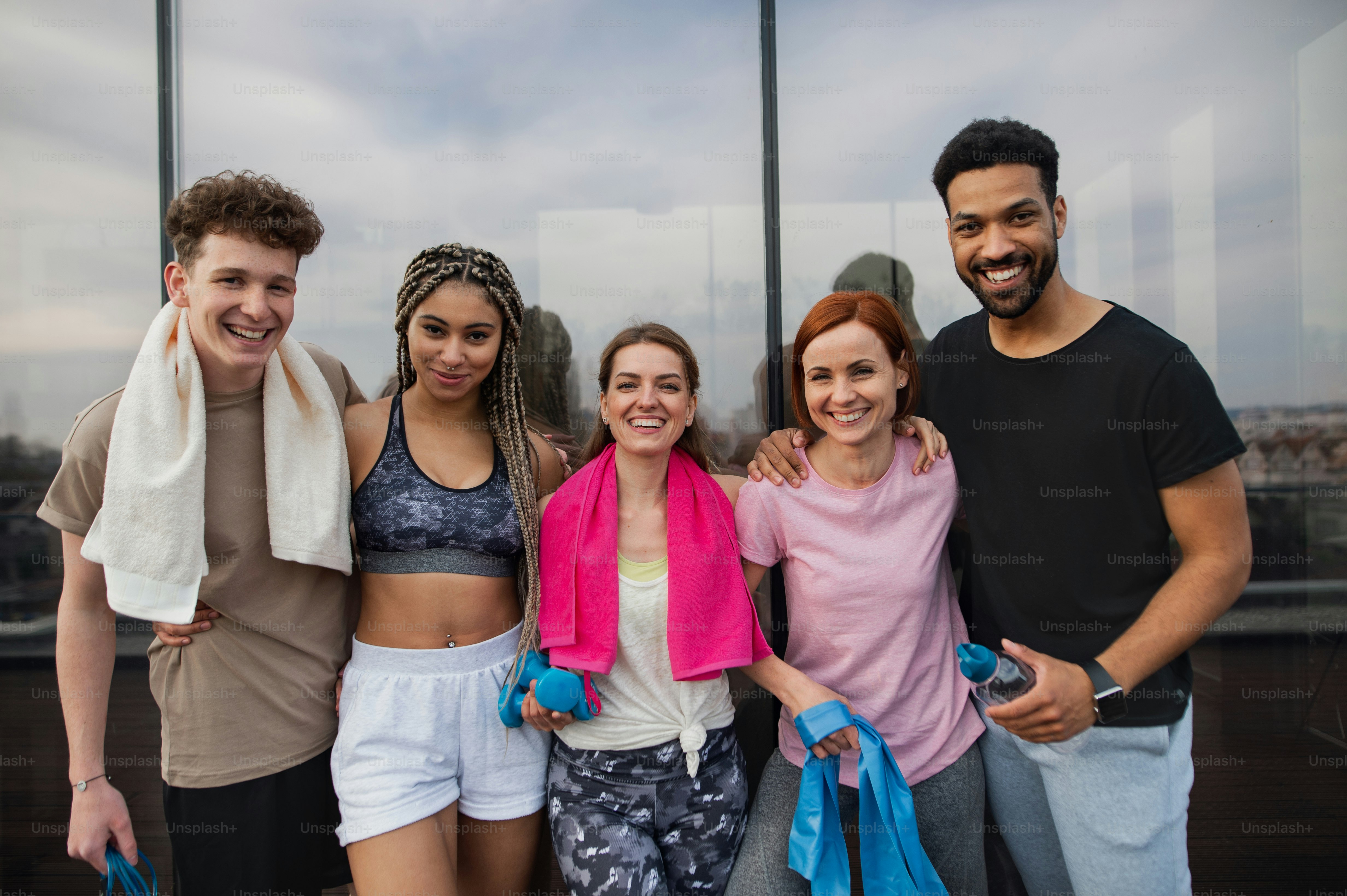 A group of young people standing after exercise outdoors on terrace ...