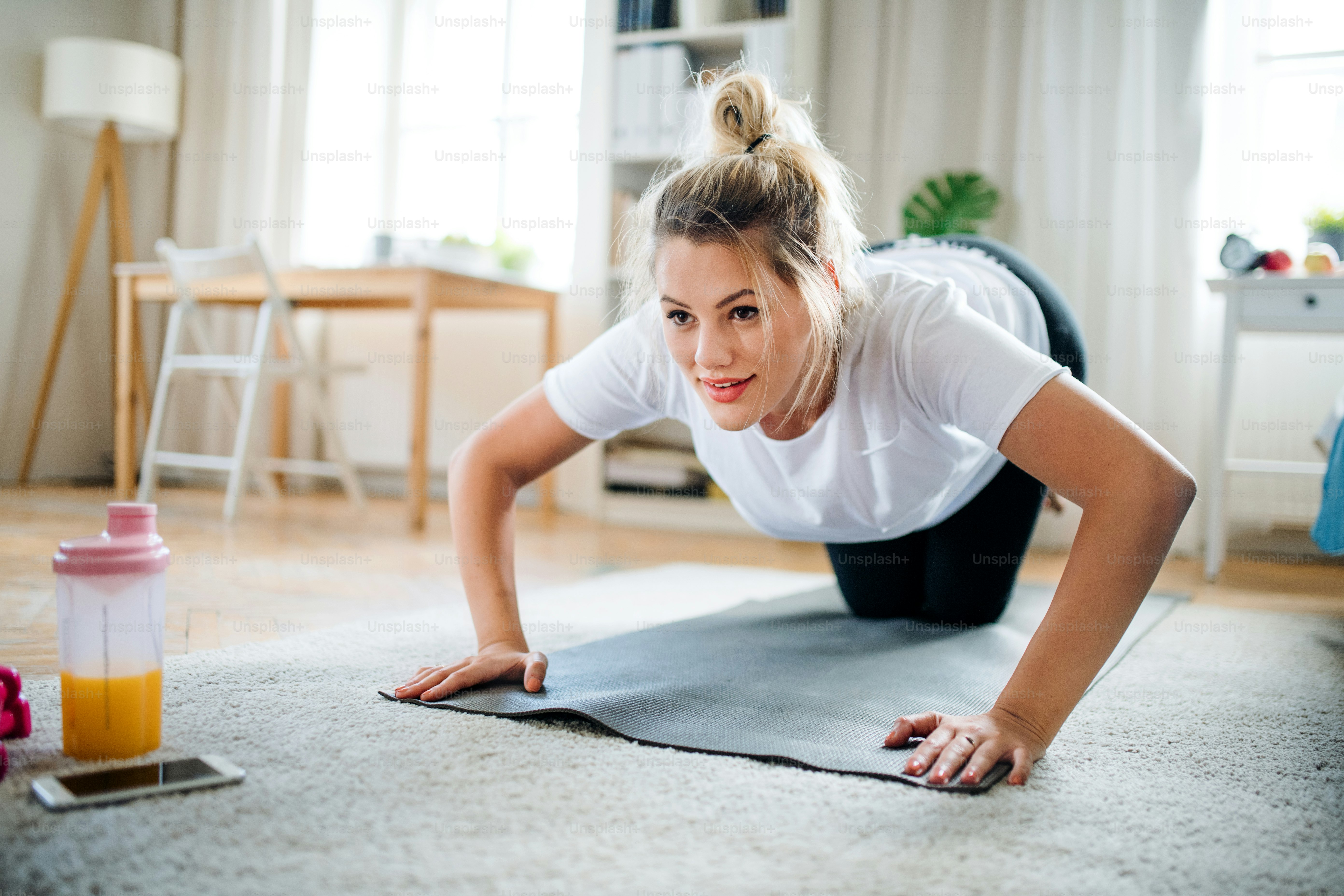 A young woman doing exercise on the floor indoors at home. photo ...