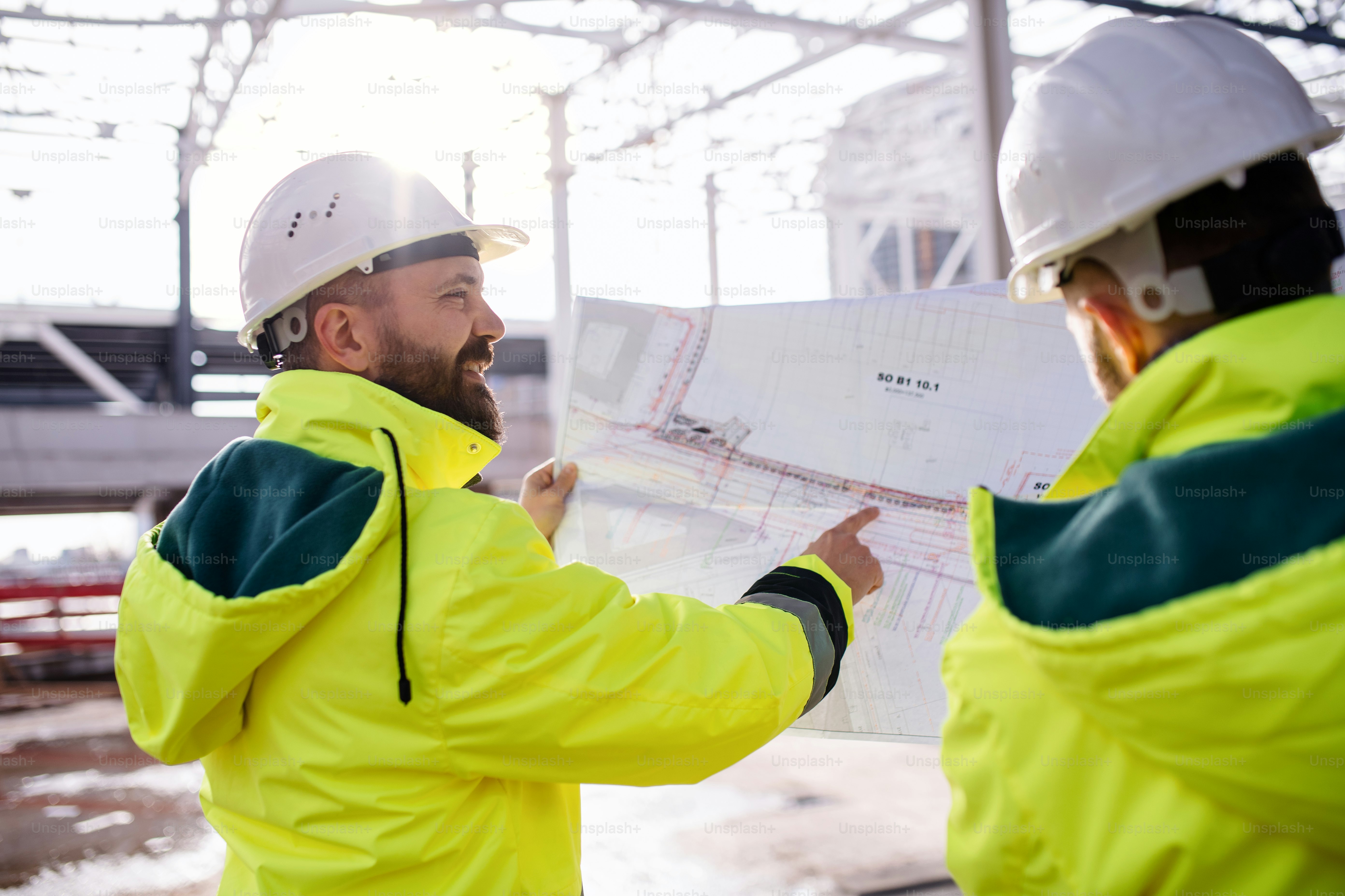 A group of engineers standing against concrete wall on construction ...