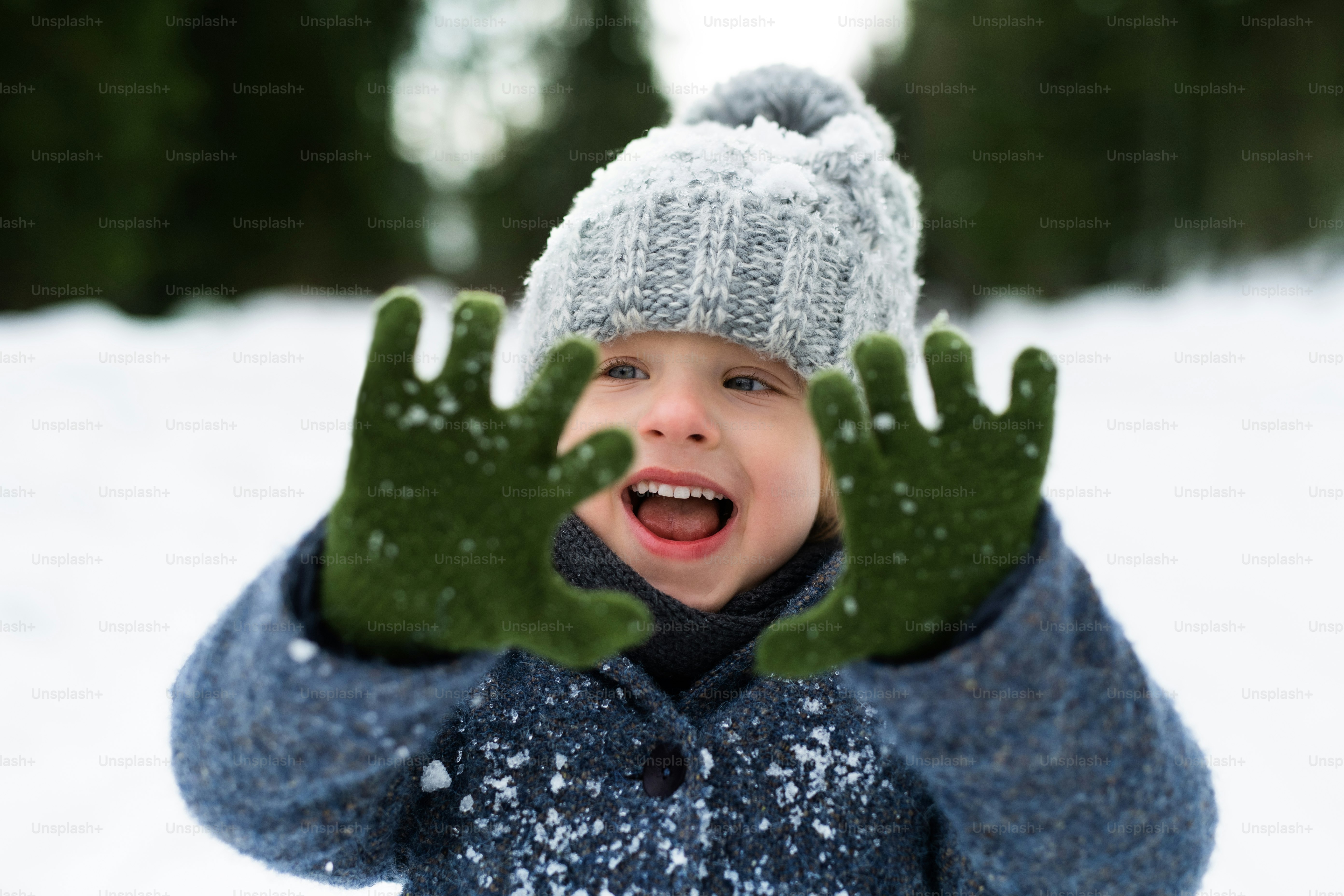Front view of unhappy and sad small child standing in snow, holiday in ...