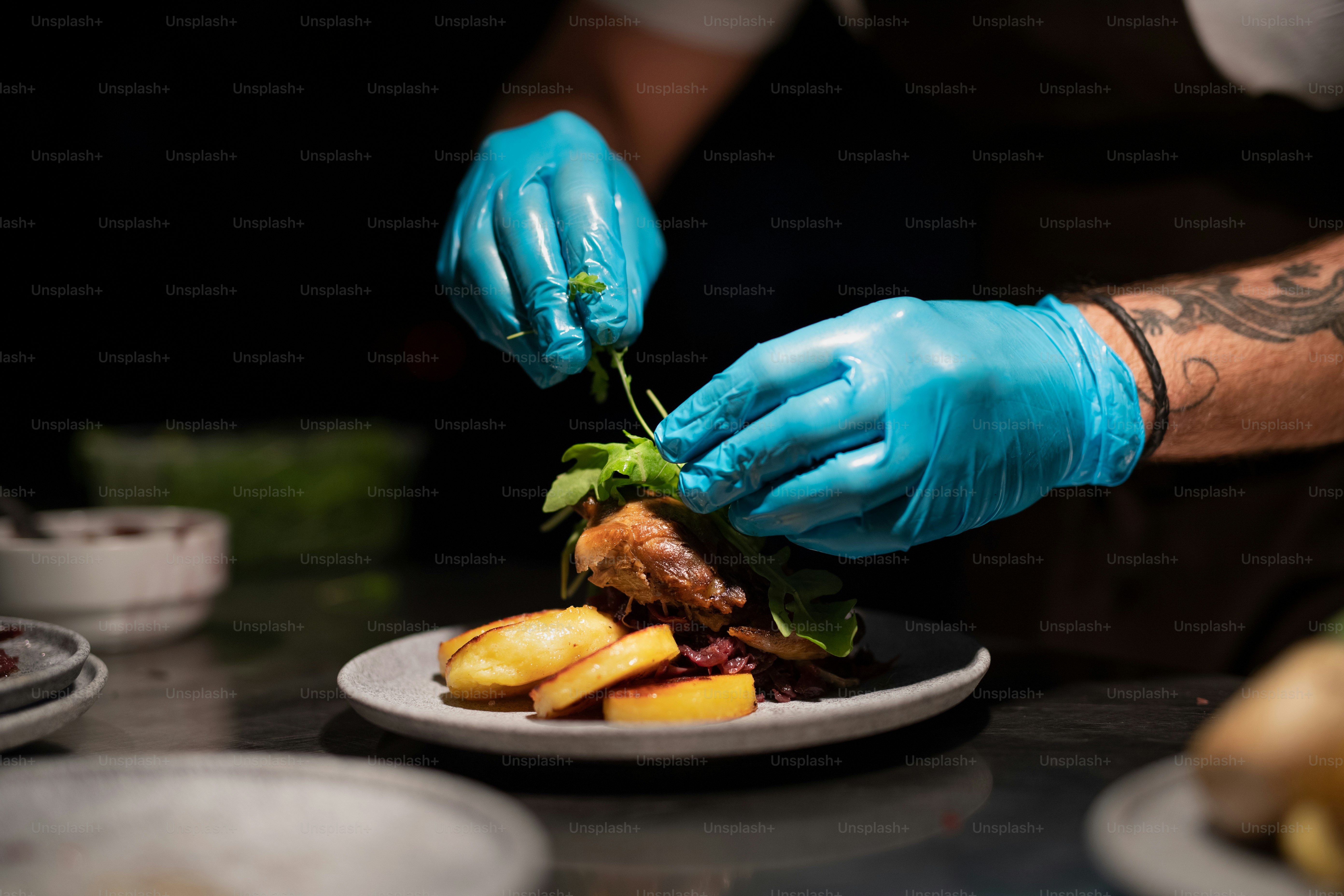 Foto Las manos del chef con guantes sirviendo y decorando su comida en ...