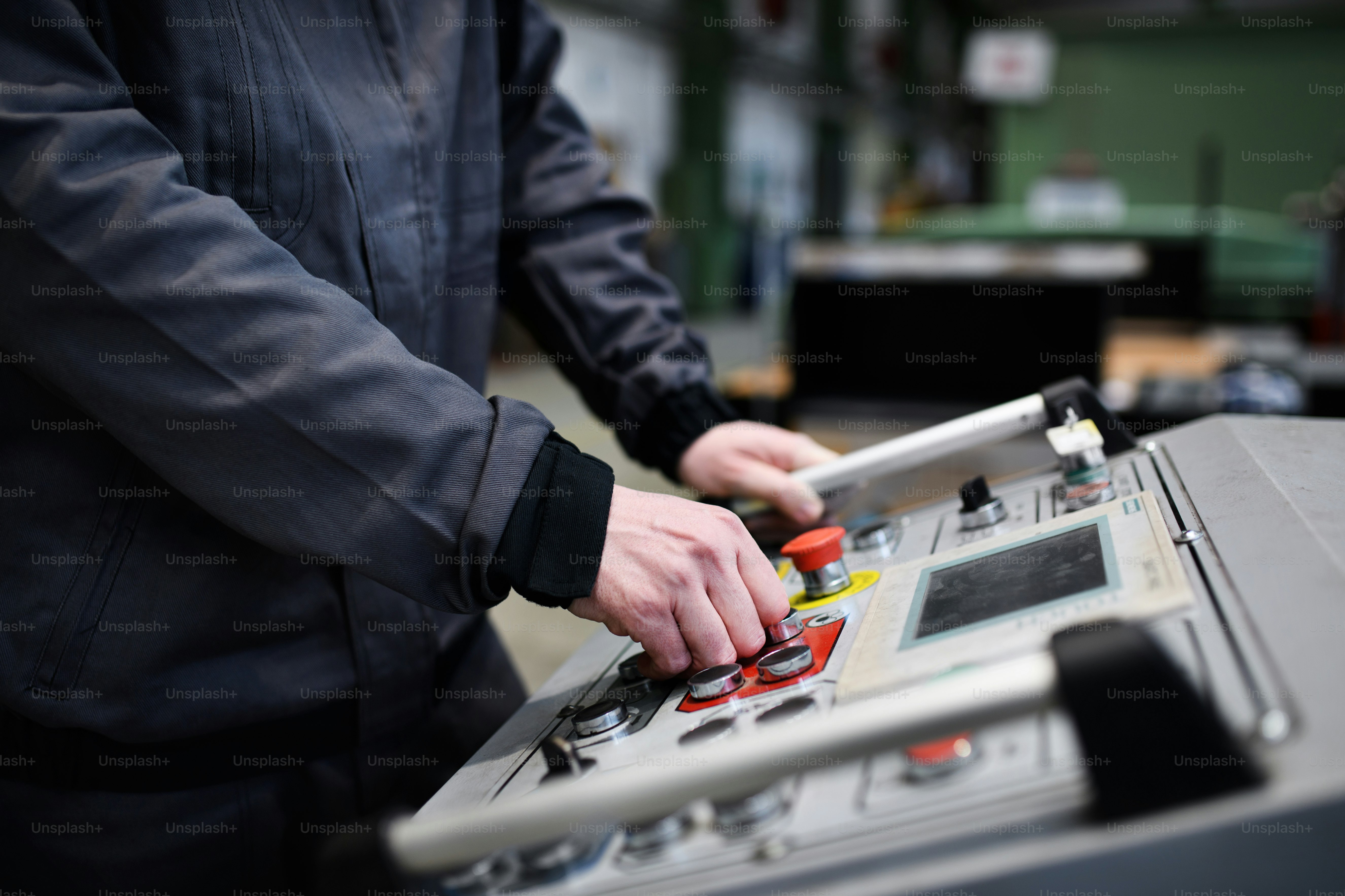 Close-up of an engineer working at machine in industrial factory photo ...
