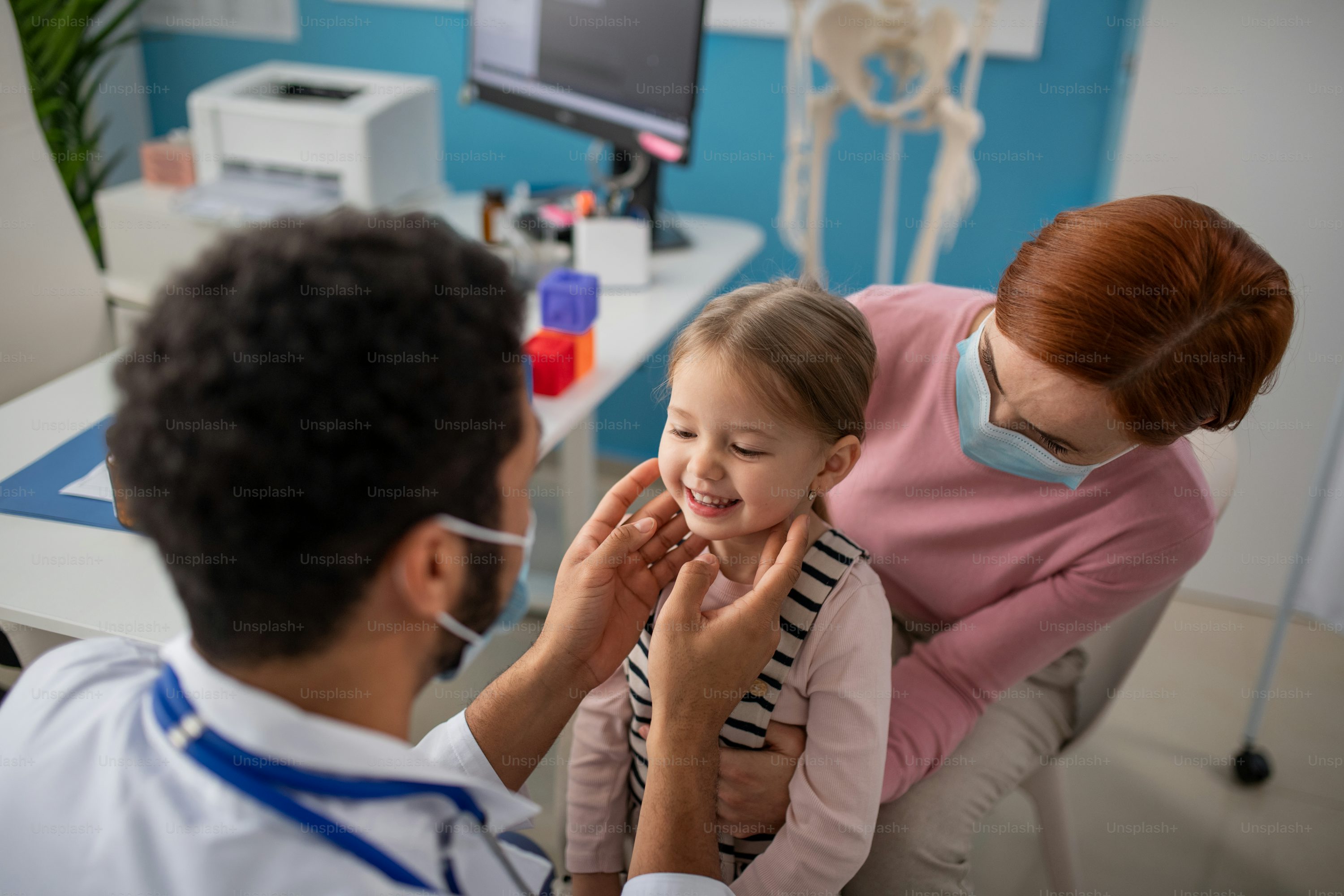 A young male doctor checking little girl's lymph nodes in his office ... A young male doctor checking little girl's lymph nodes in his office ...
