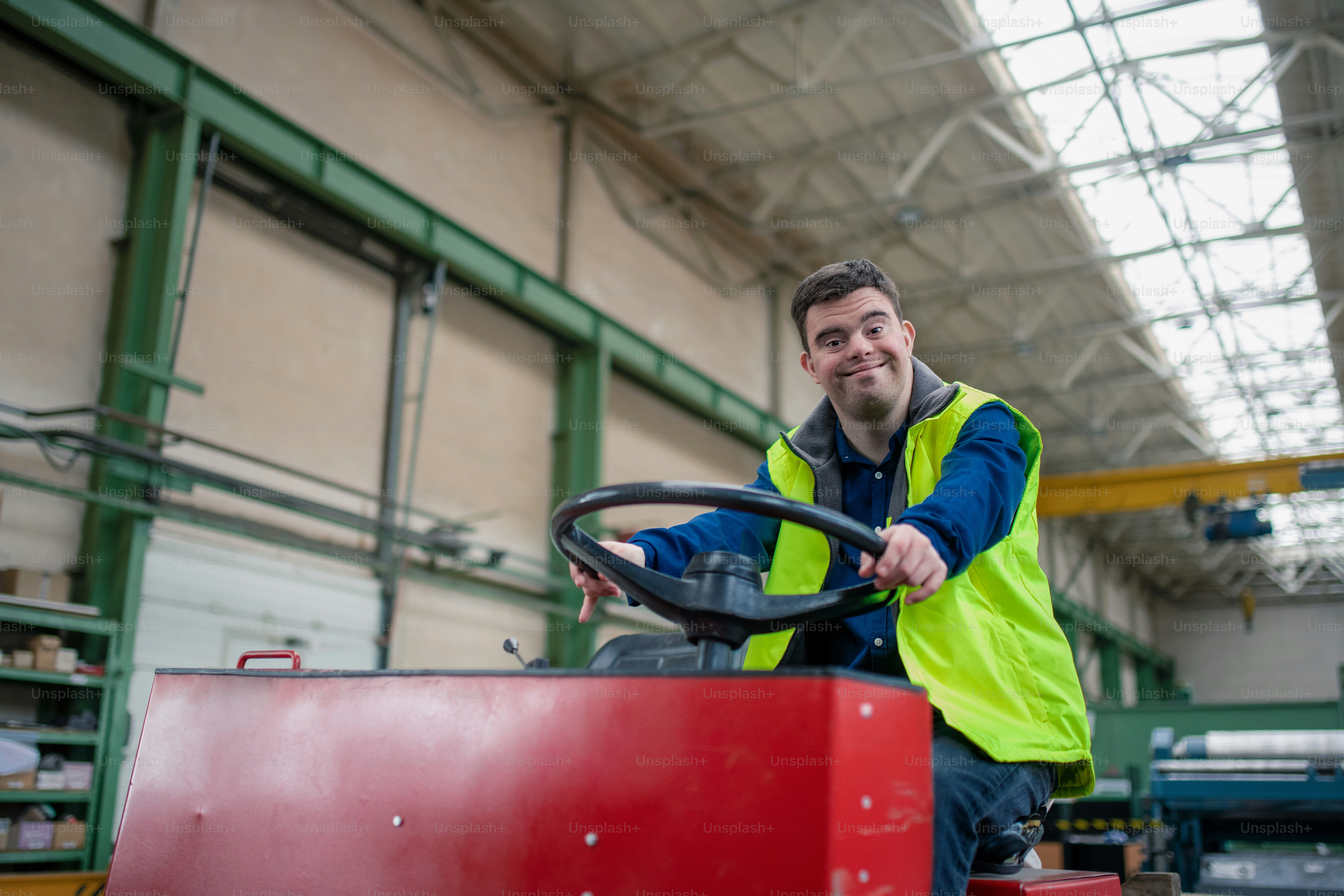 A young man with Down syndrome working in industrial factory, social ...