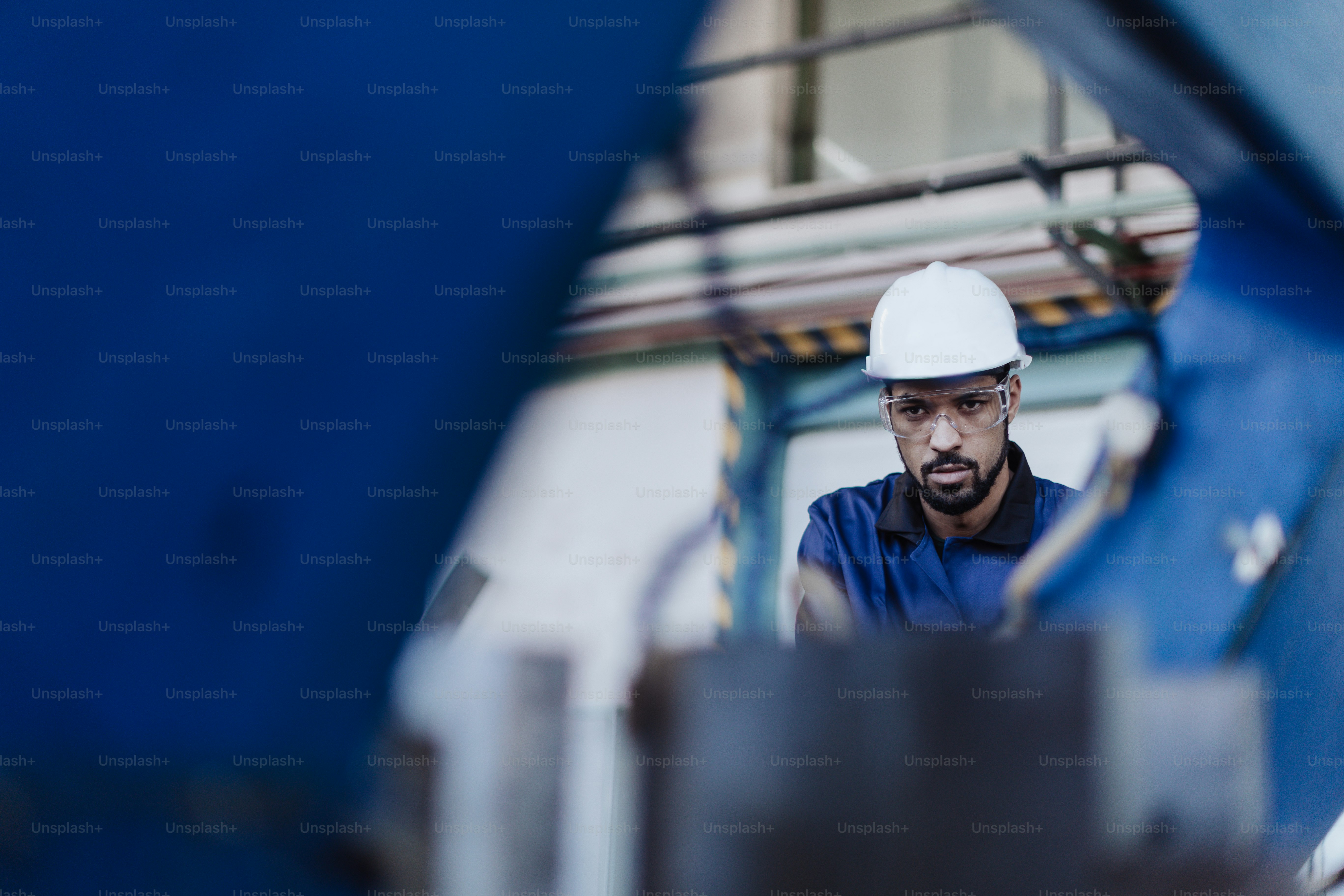 A factory male worker in plant production drilling at metal machine in ...