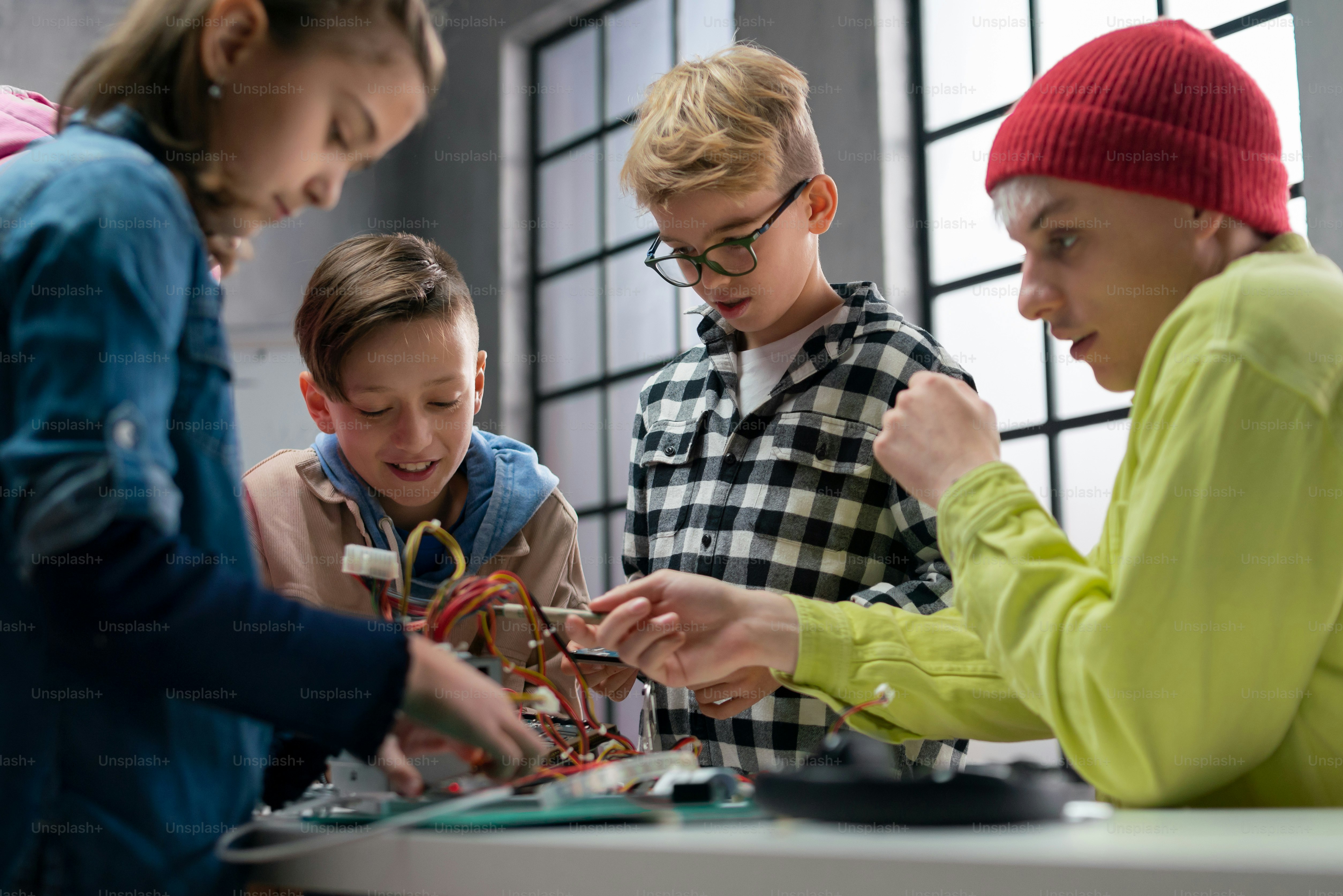 A group of happy kids with their science teacher with electric toys and ...