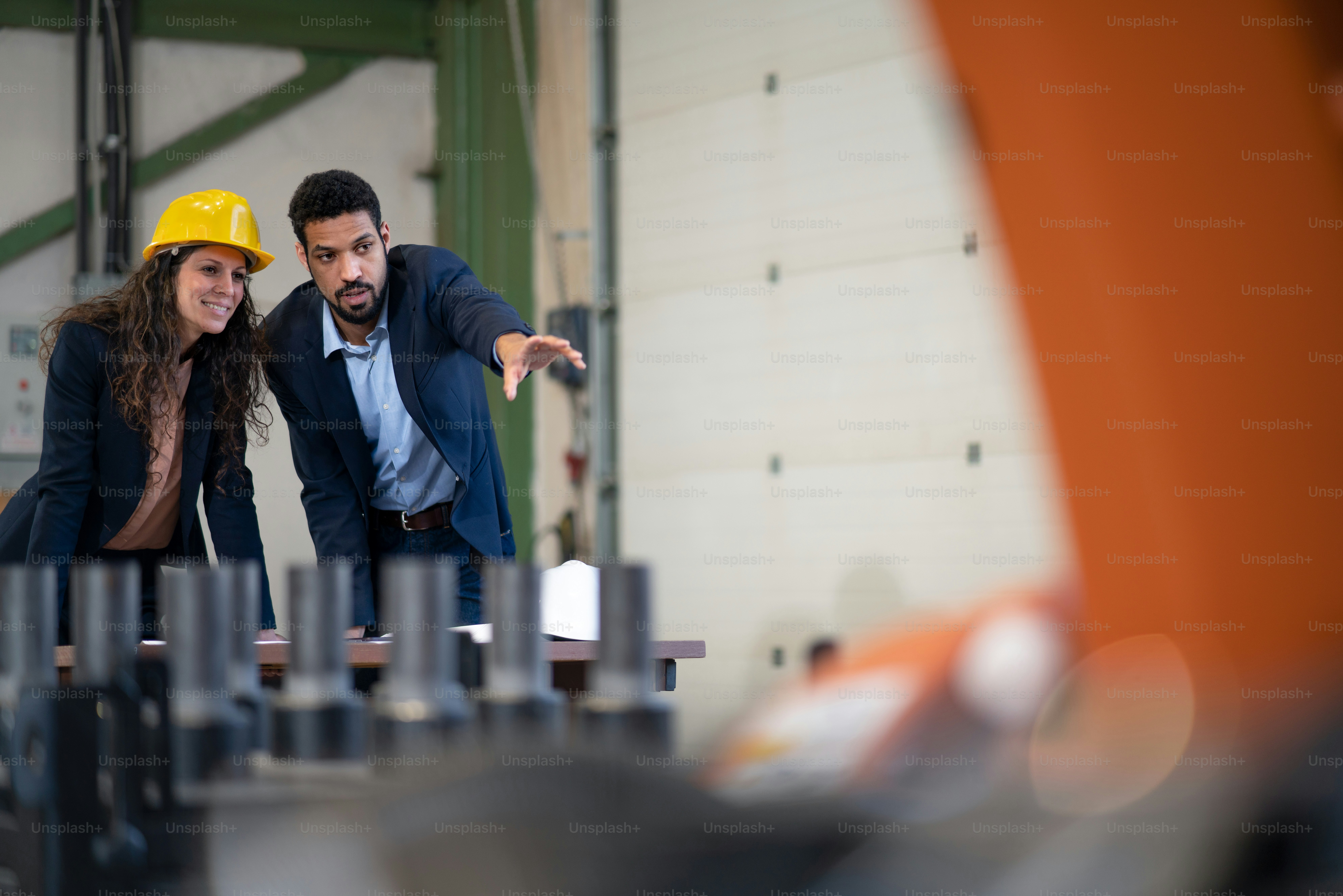 A man engineer showing machines to his collegue in industrial robotic ...