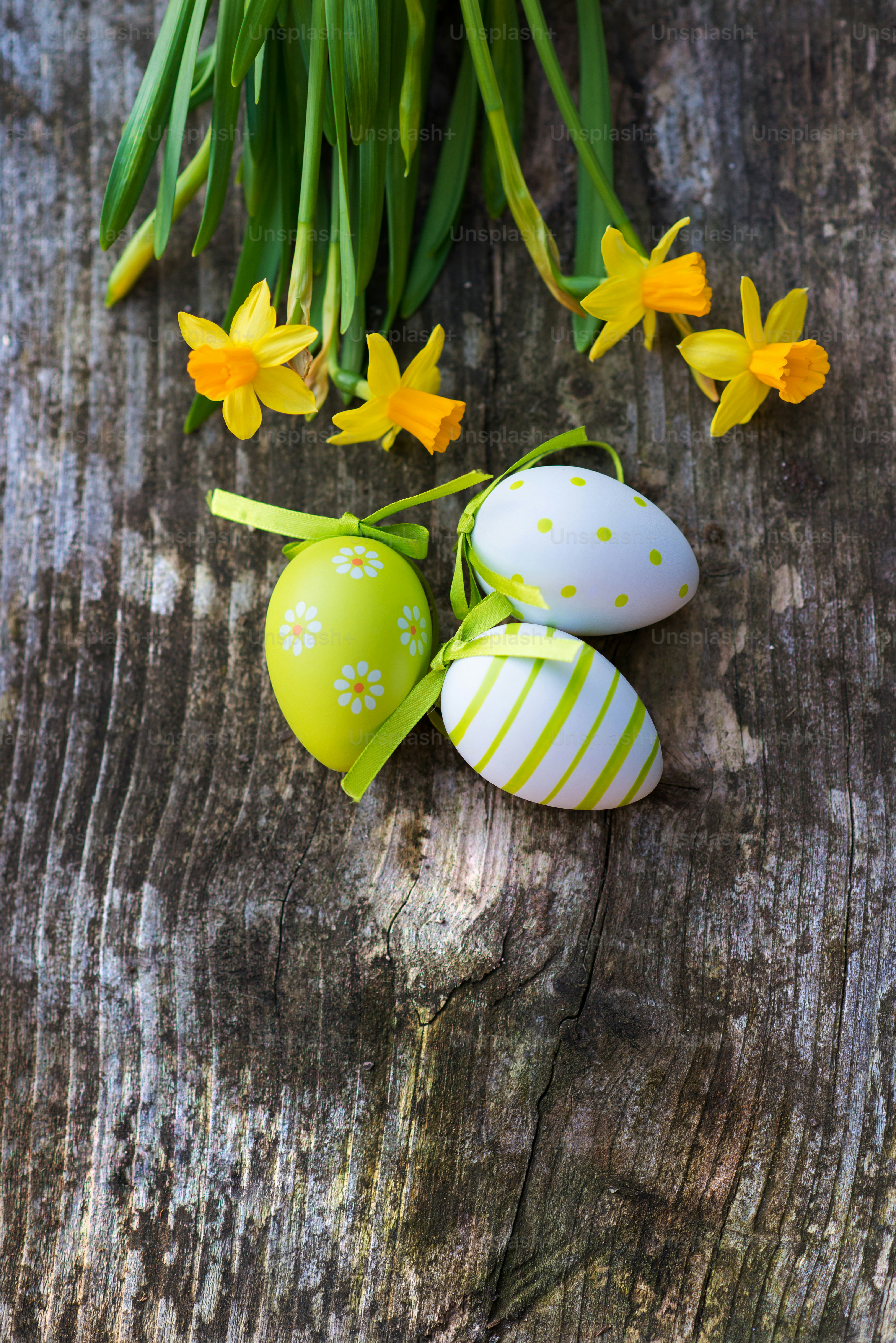 Colorful easter eggs and beautiful spring flowers laid on a wooden ...