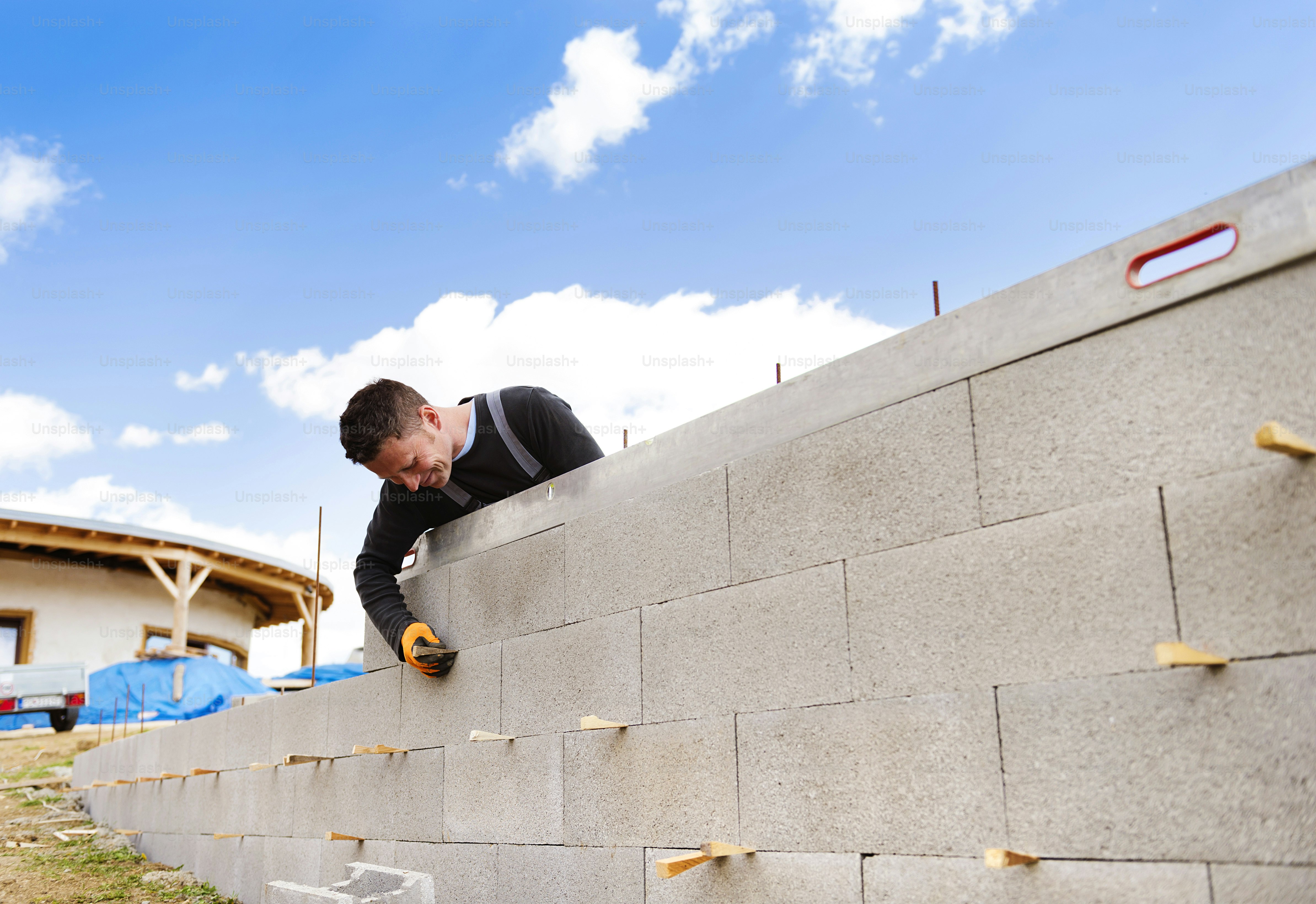 Bricklayer putting down another row of bricks in site photo – Cloud ...