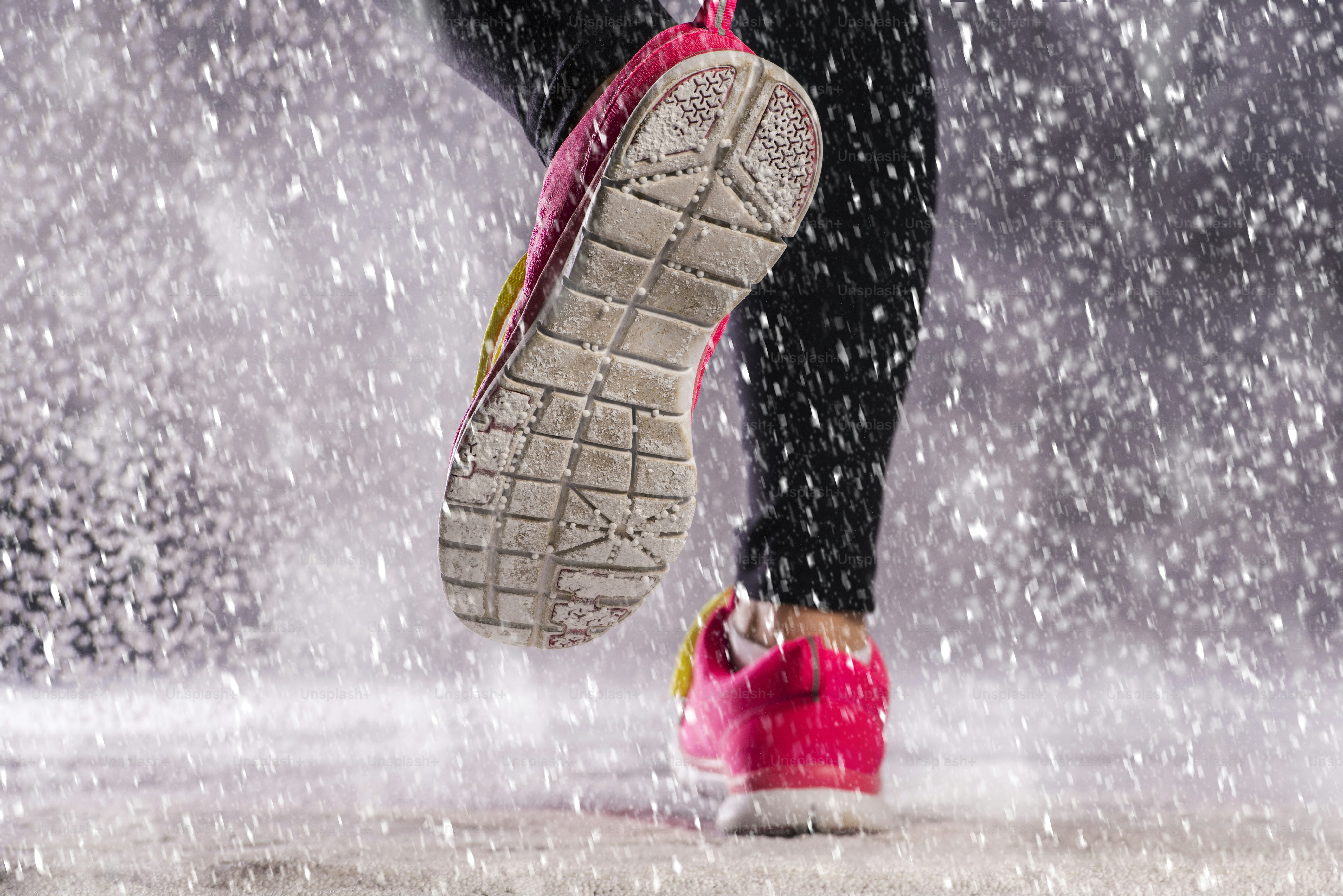 Athlete woman is running during winter training outside in cold snow ...