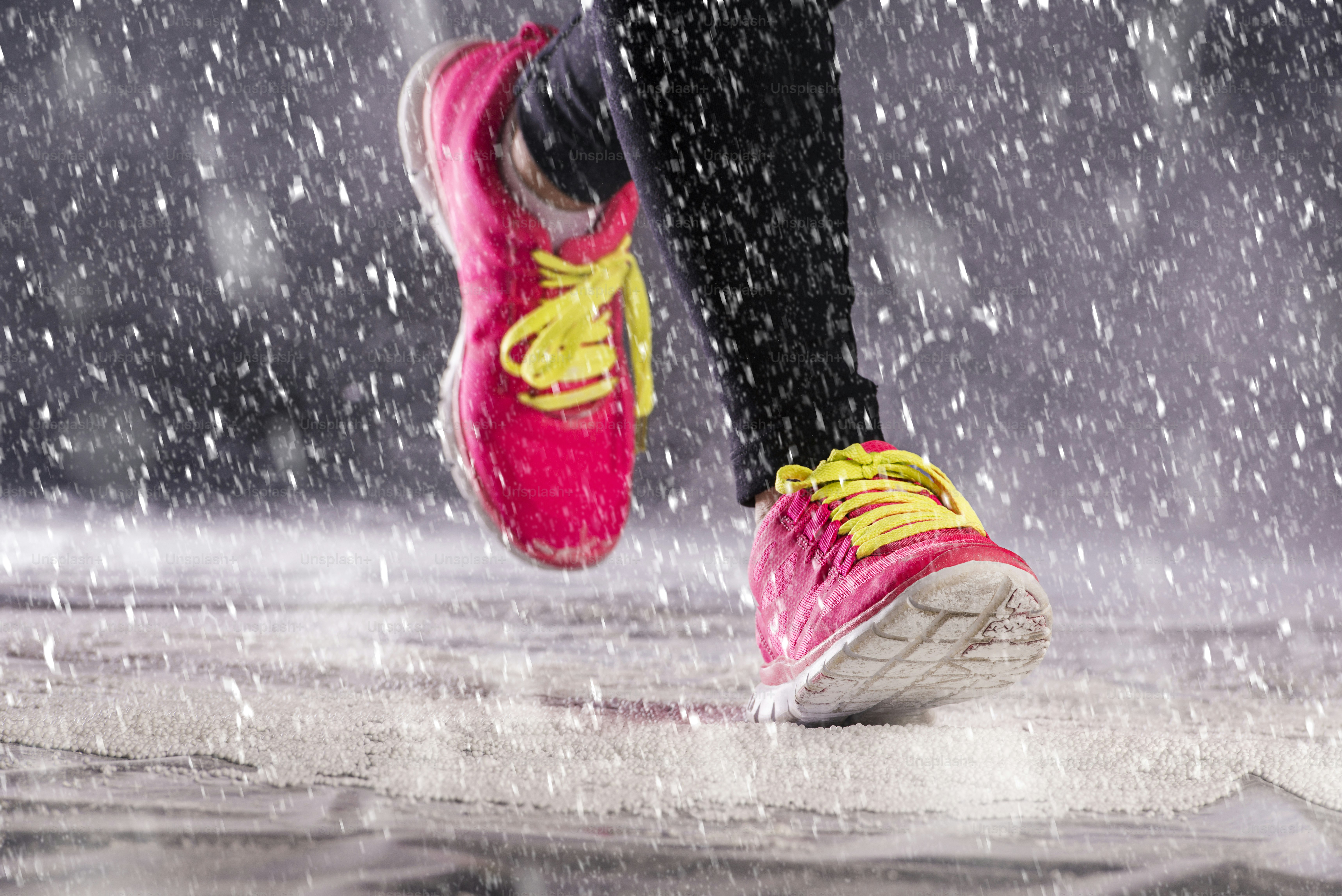 Athlete woman is running during winter training outside in cold snow ...