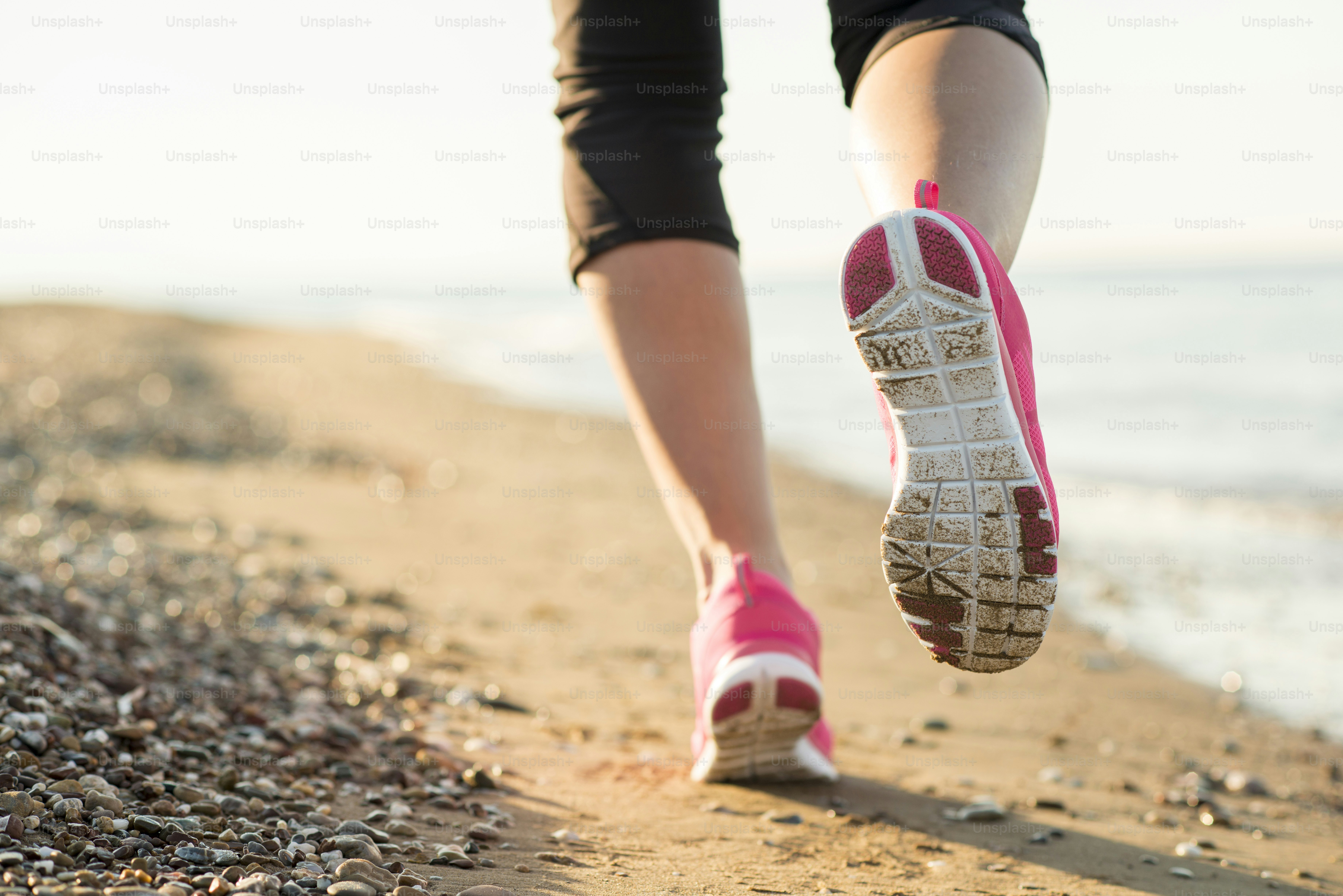 Young woman is running in sunny nature along the beach photo ...