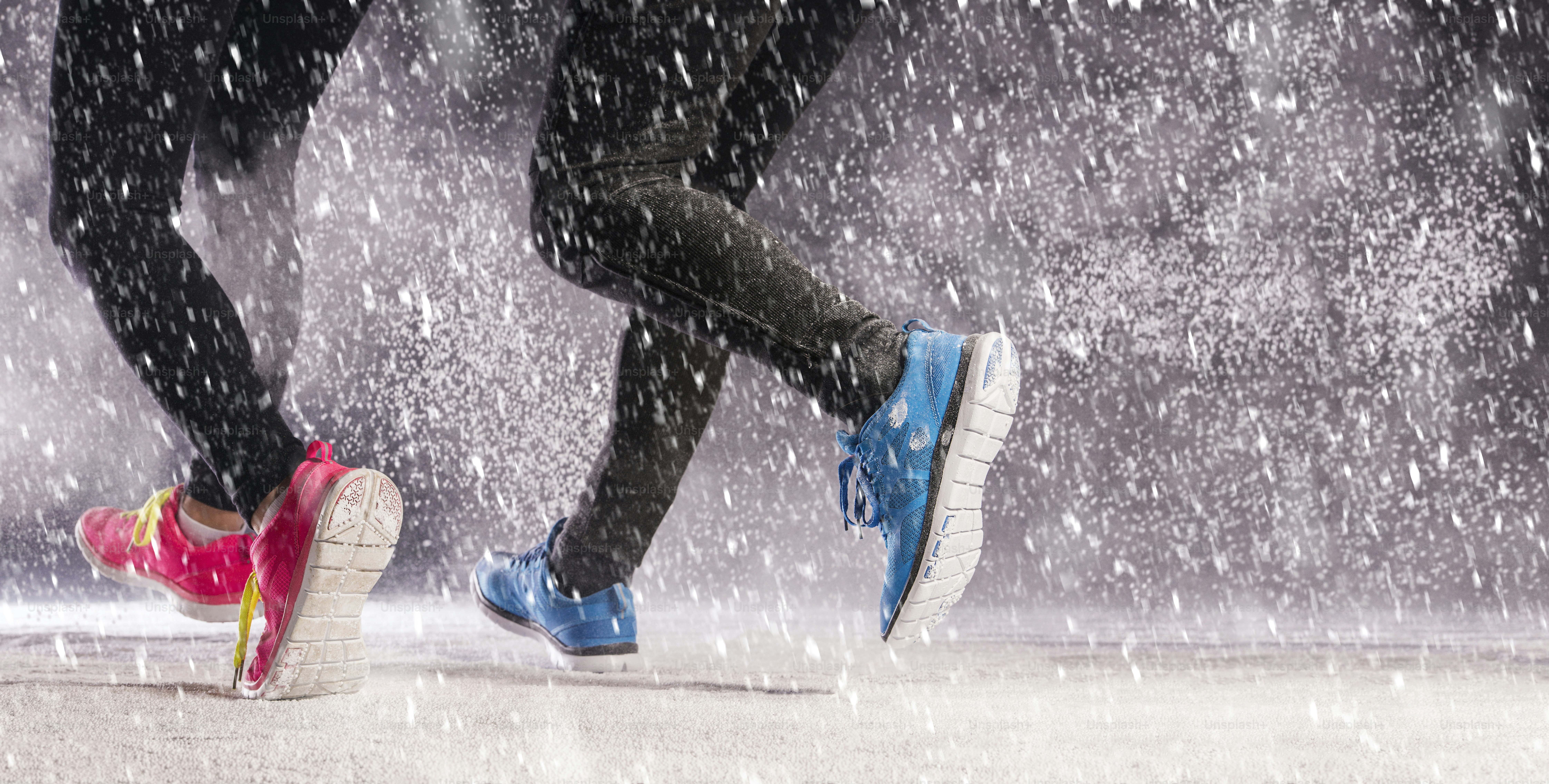 Athlete woman is running during winter training outside in cold snow ...