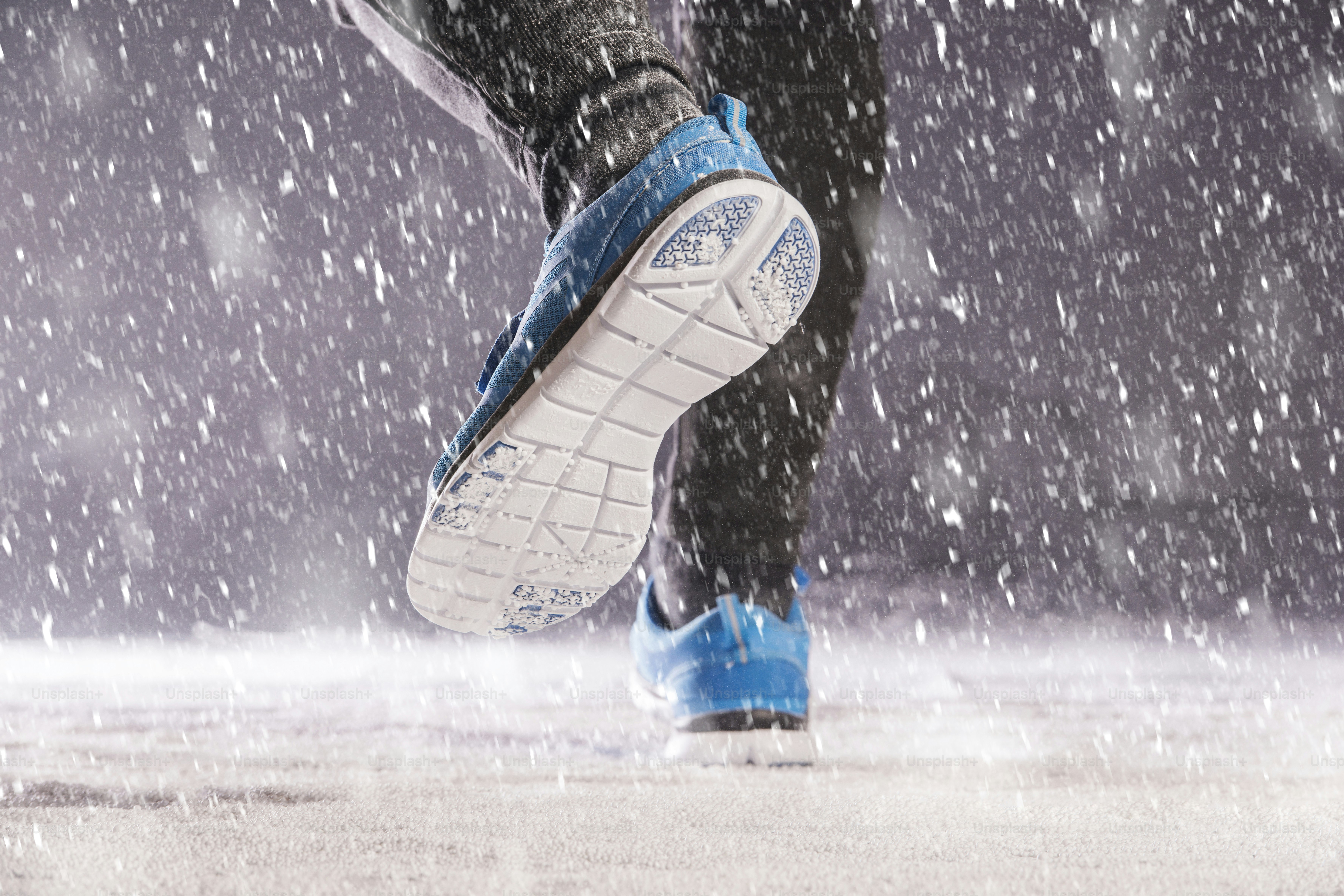Athlete woman is running during winter training outside in cold snow ...