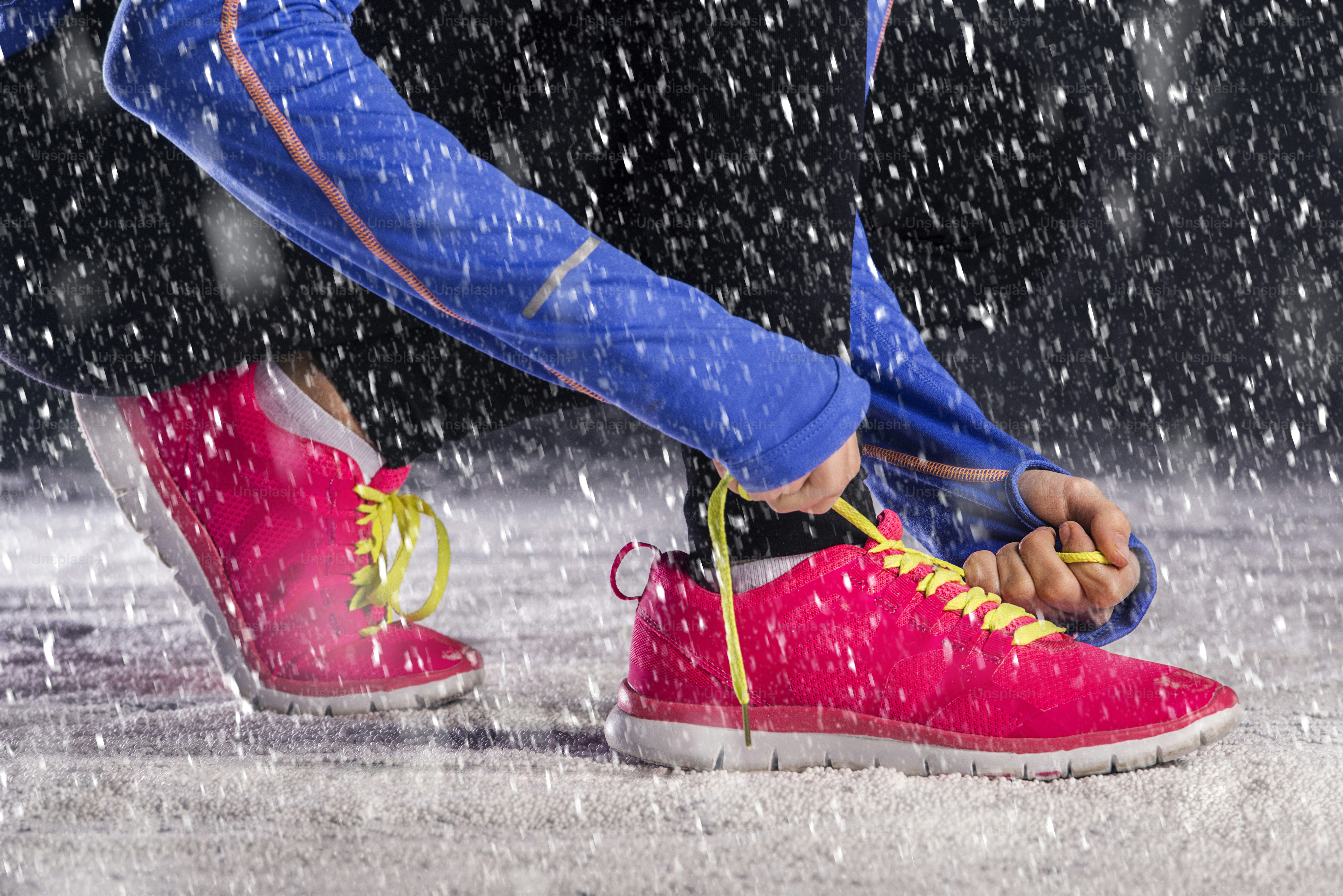 Athlete woman is running during winter training outside in cold snow ...