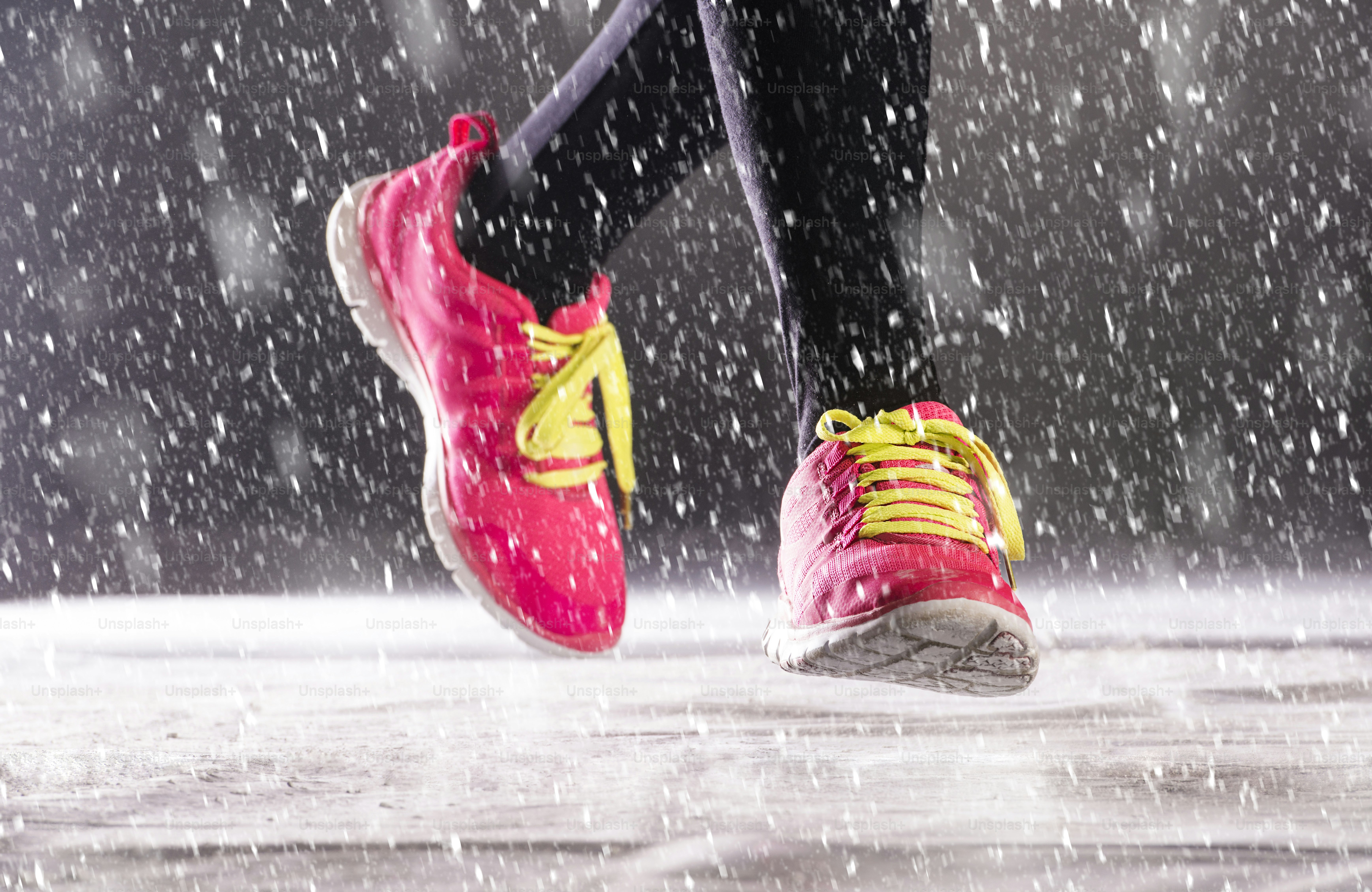 Athlete woman is running during winter training outside in cold snow ...