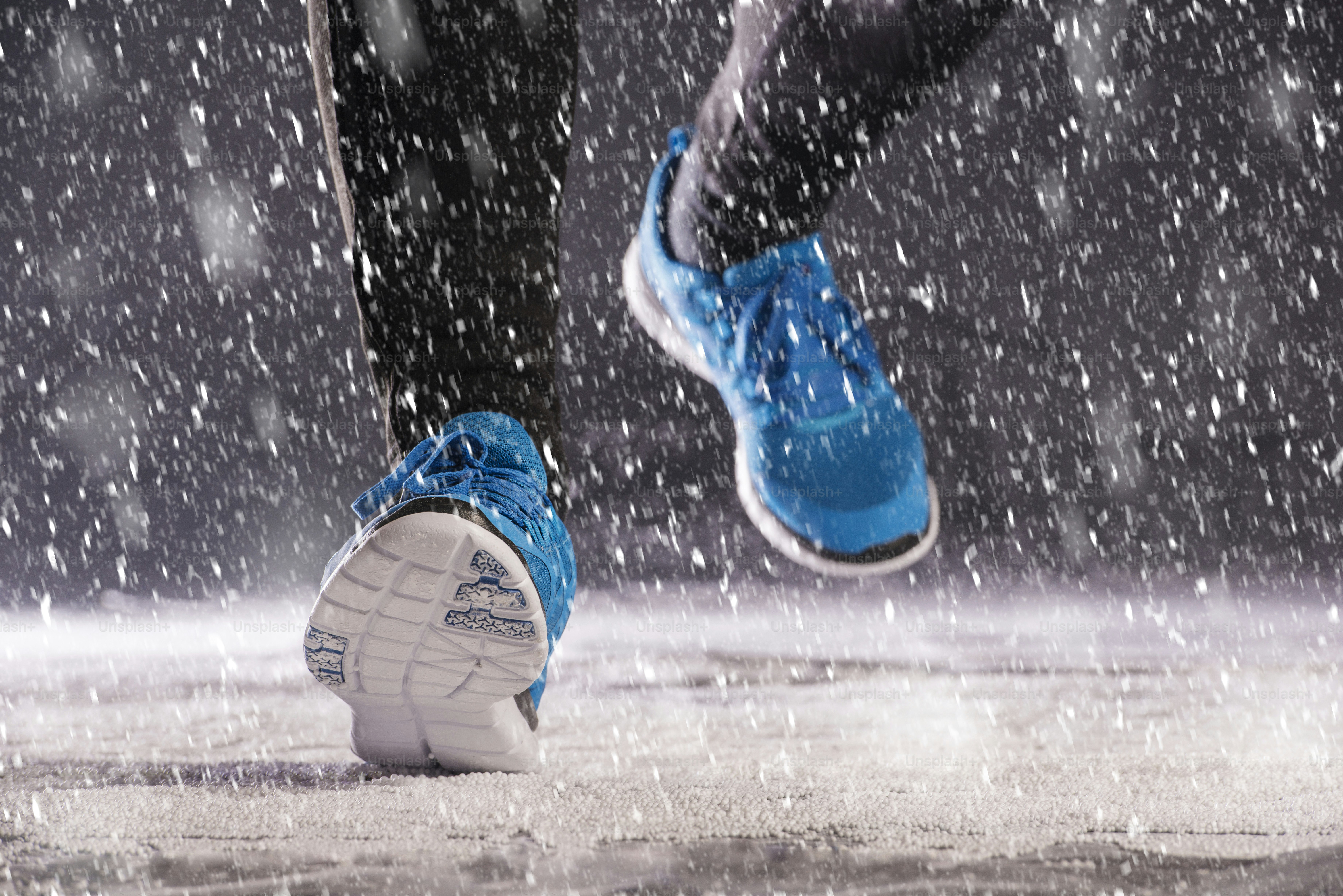 Athlete woman is running during winter training outside in cold snow ...