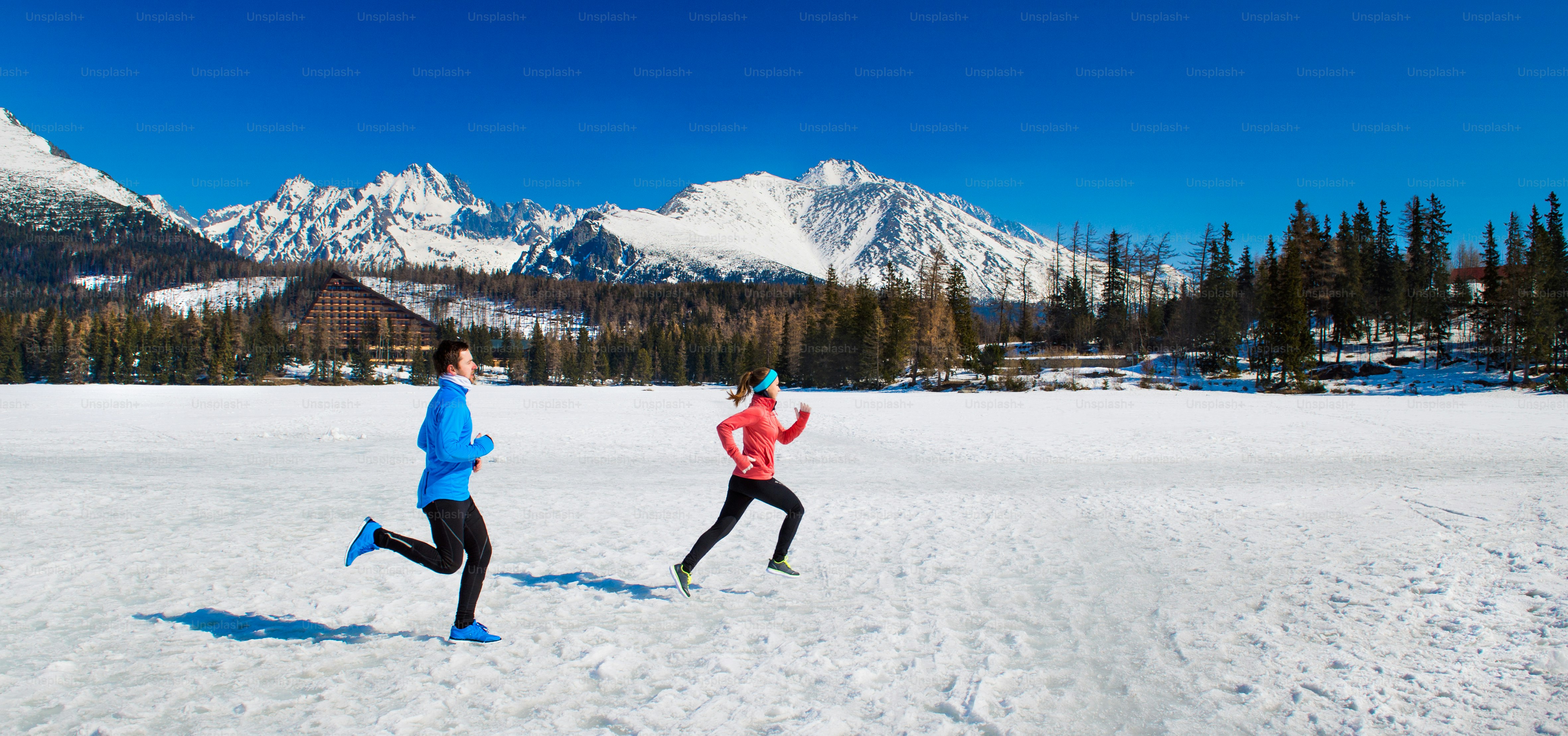 Young couple jogging outside in sunny winter mountains photo ...